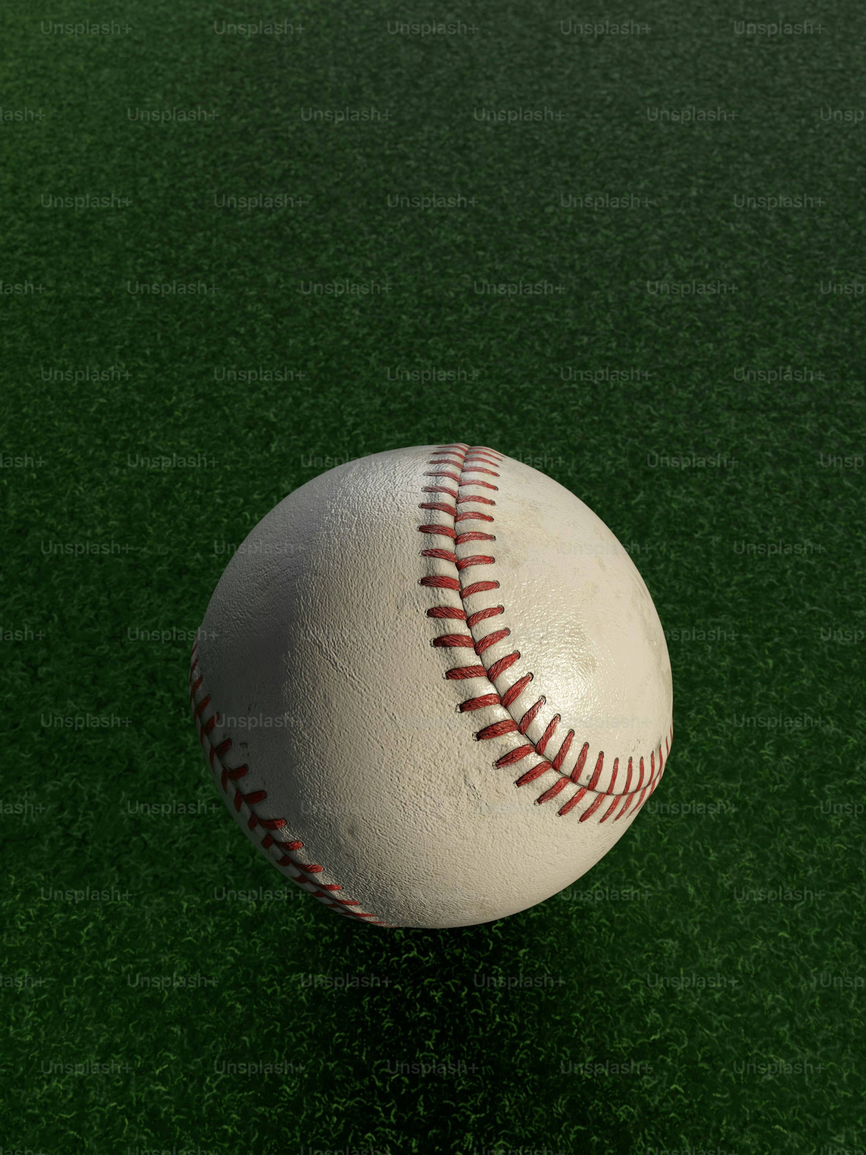 A white baseball sitting on top of a green field photo – Baseball Image ...