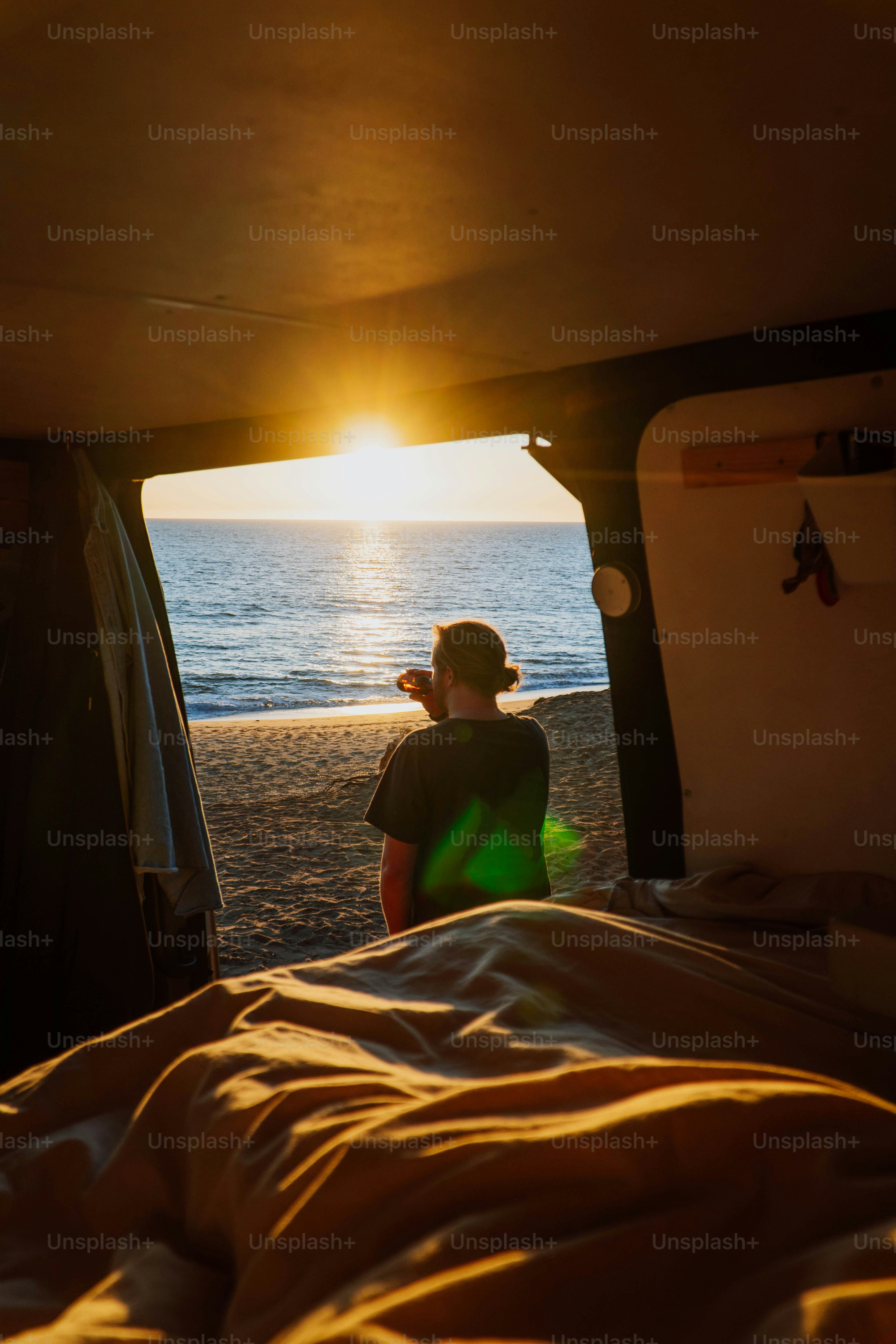 A person standing in the back of a truck on a beach photo – Spring ...