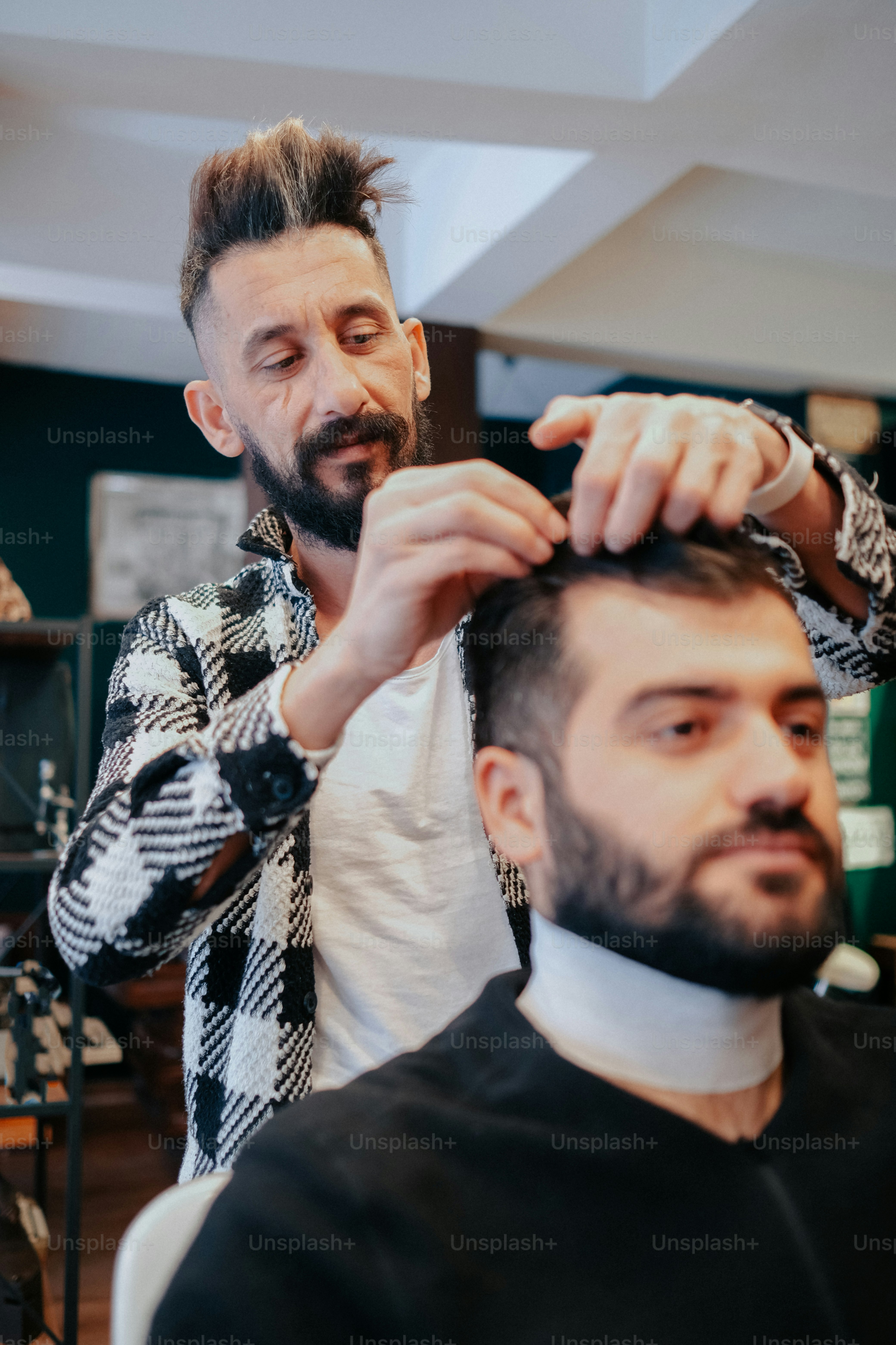 A man cutting another mans hair in a barber shop photo – Barberia Image on Unsplash