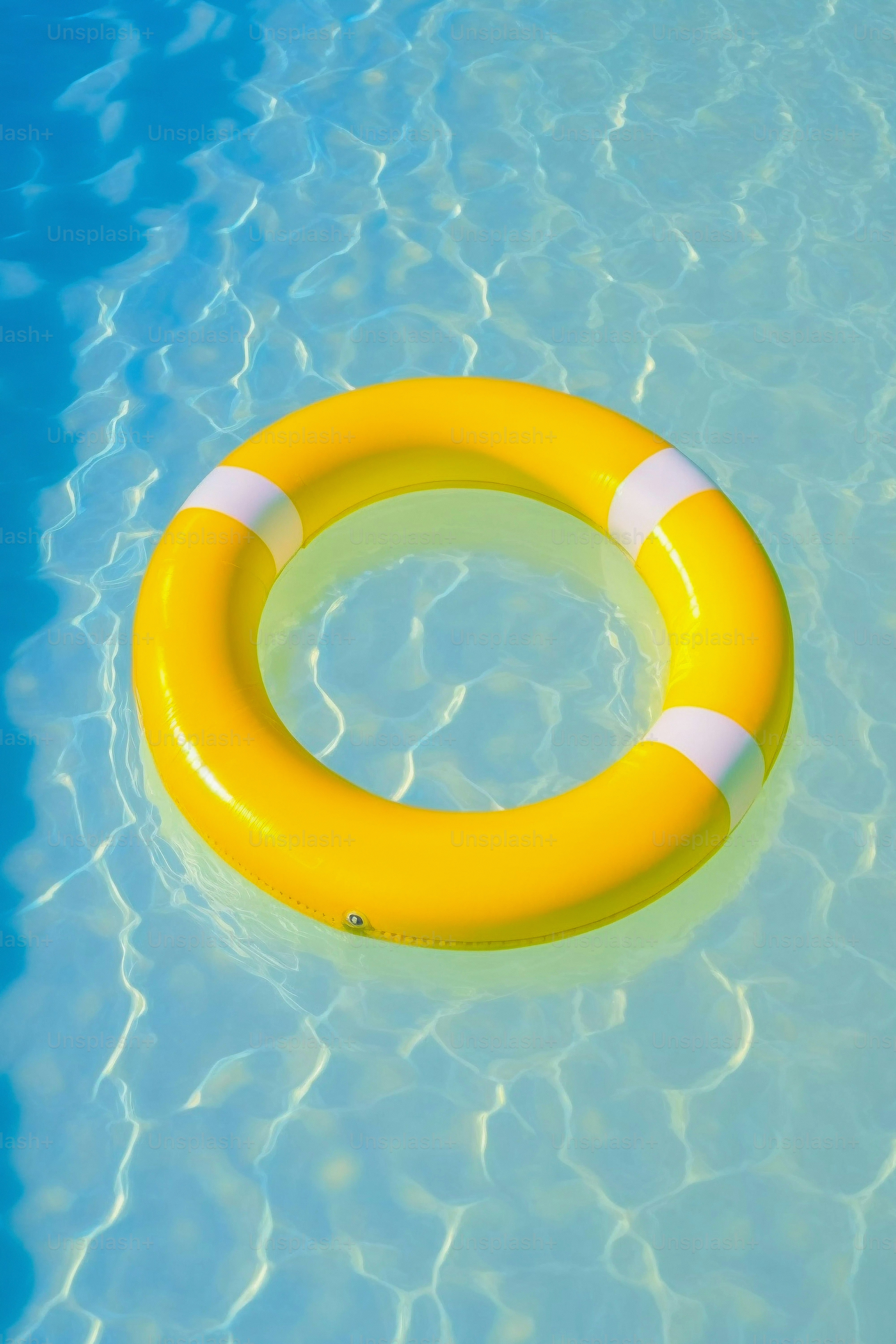 A life preserver floating in a pool of water photo – Safety Image on ...