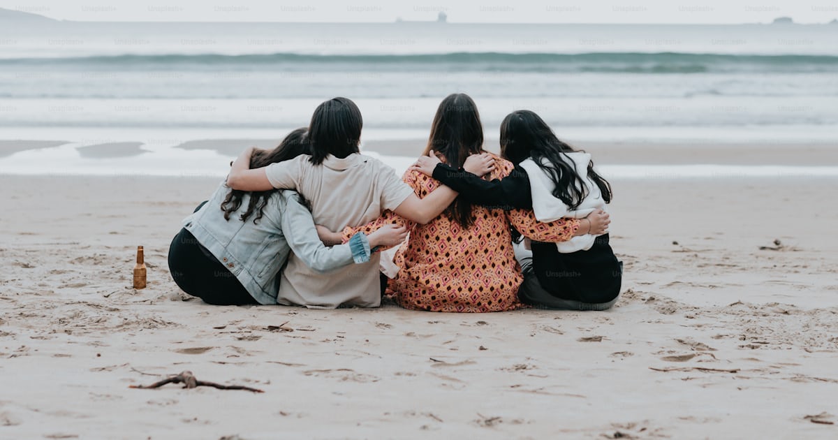 모래 사장 위에 앉아있는 사람들의 그룹 사진 Unsplash의 휴가 이미지