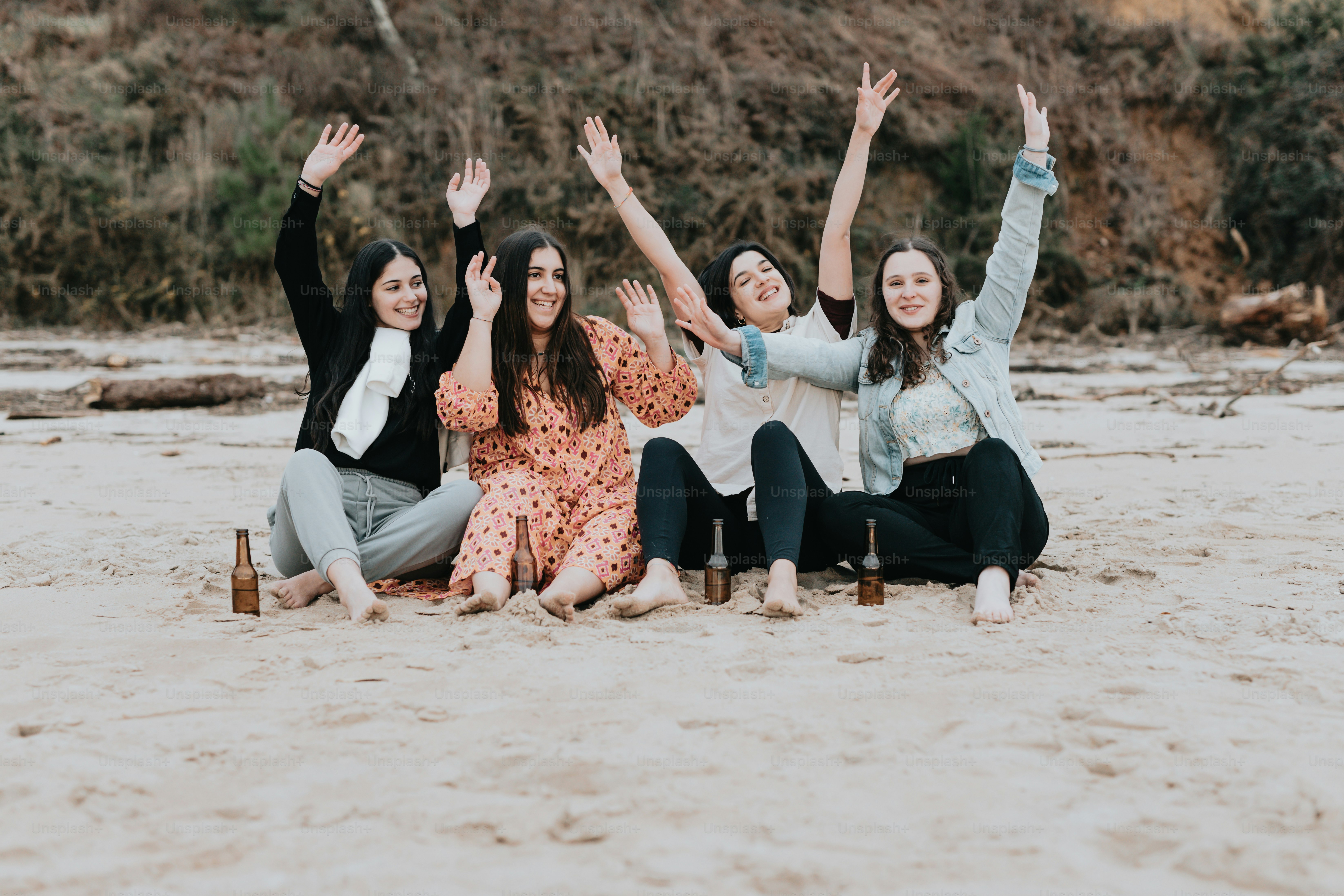 A group of women sitting on top of a sandy beach photo – Spring break ...