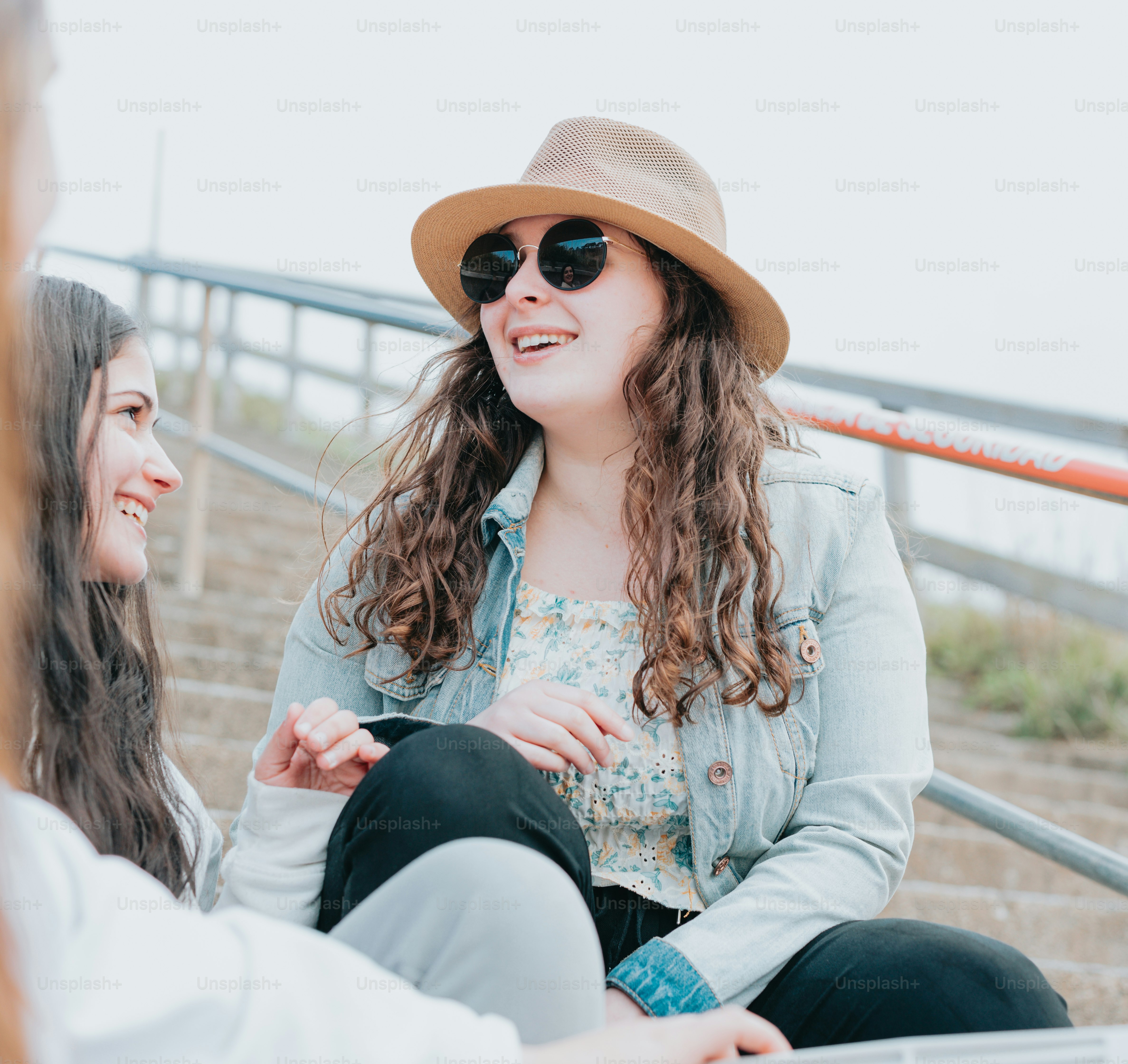 two women sitting on steps talking to each other photo – Getaway Image ...