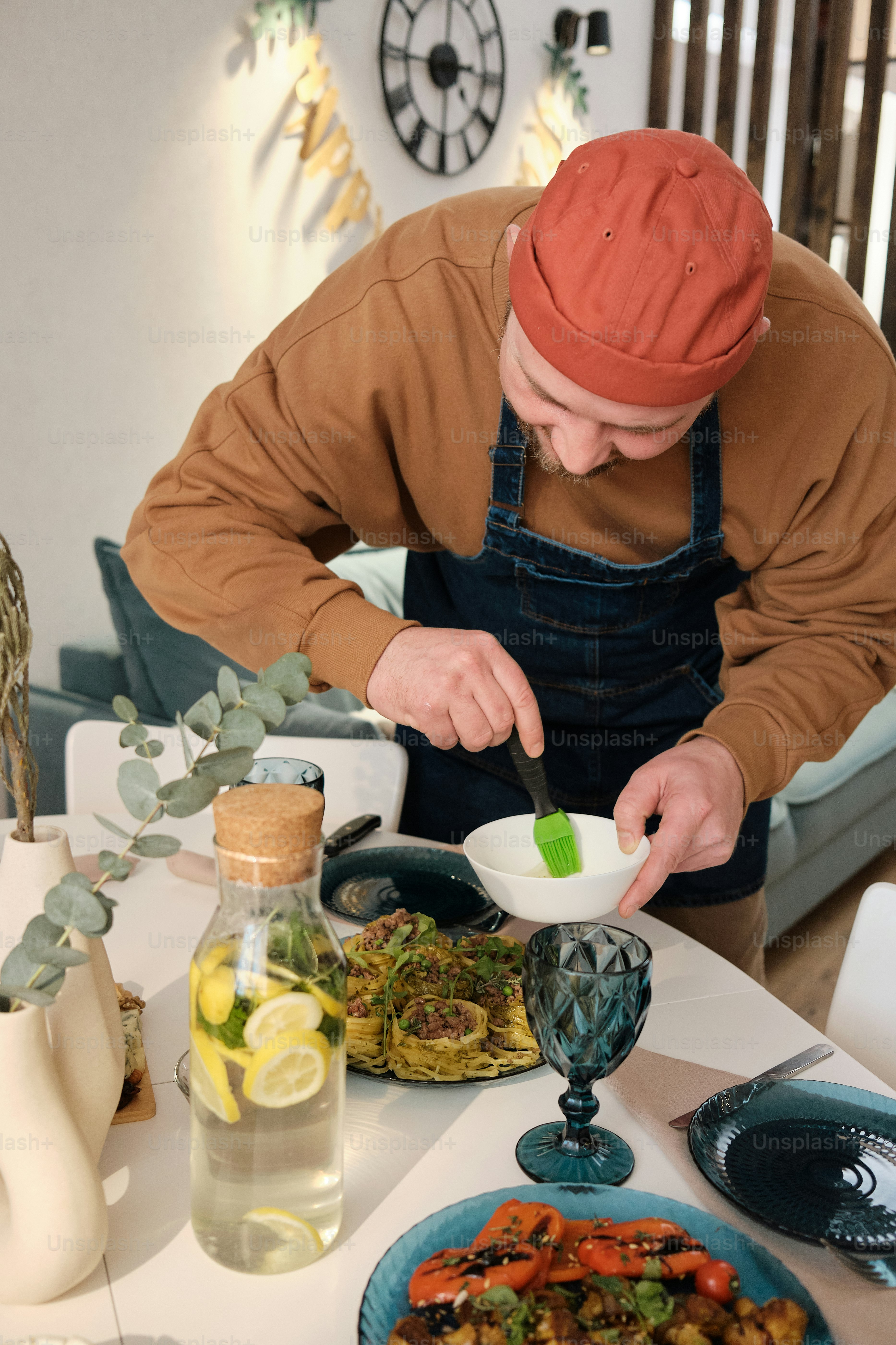 A man standing over a table filled with food photo – Dinner party Image ...