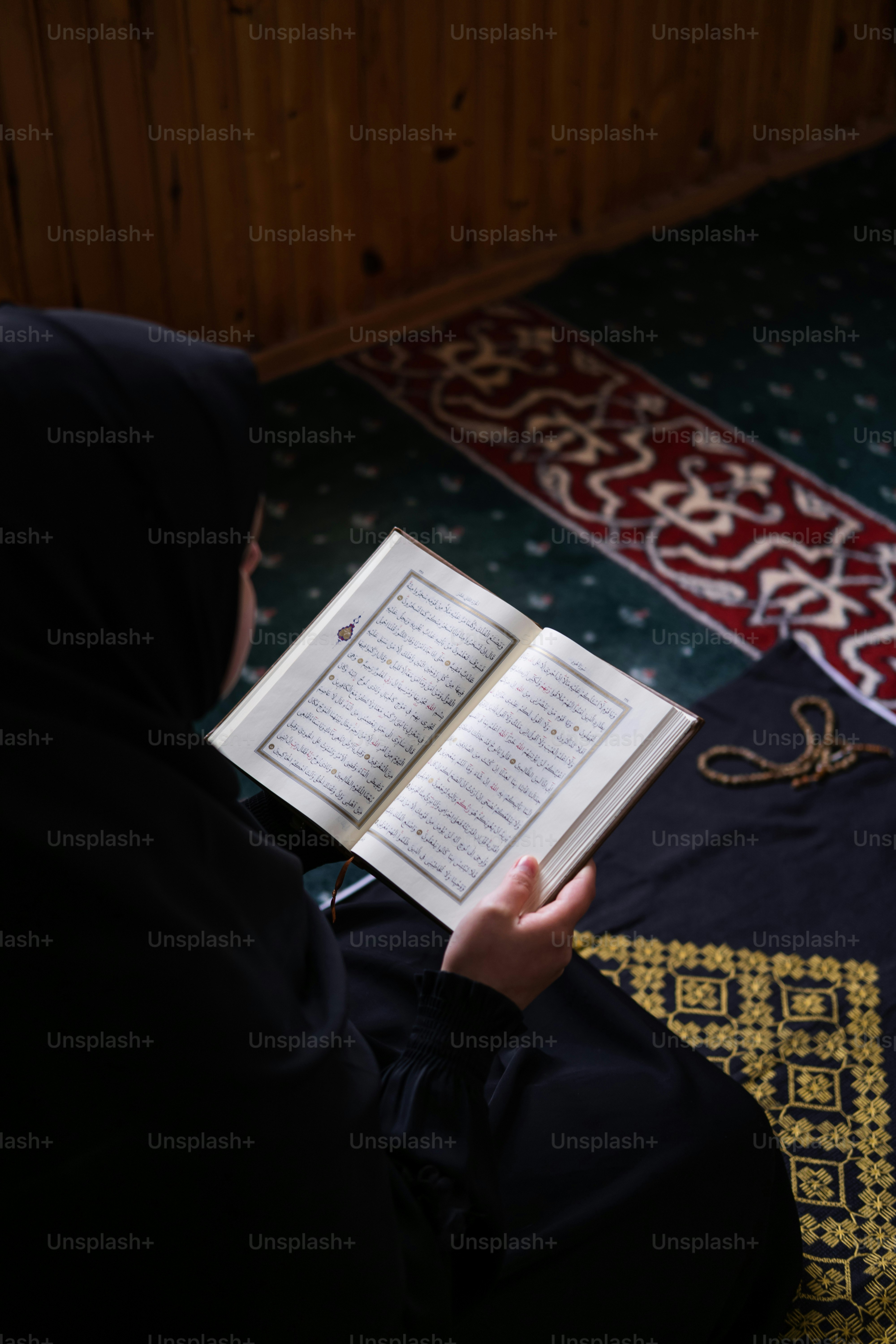 Foto Una persona sentada en el suelo leyendo un libro – Islam Imagen en ...