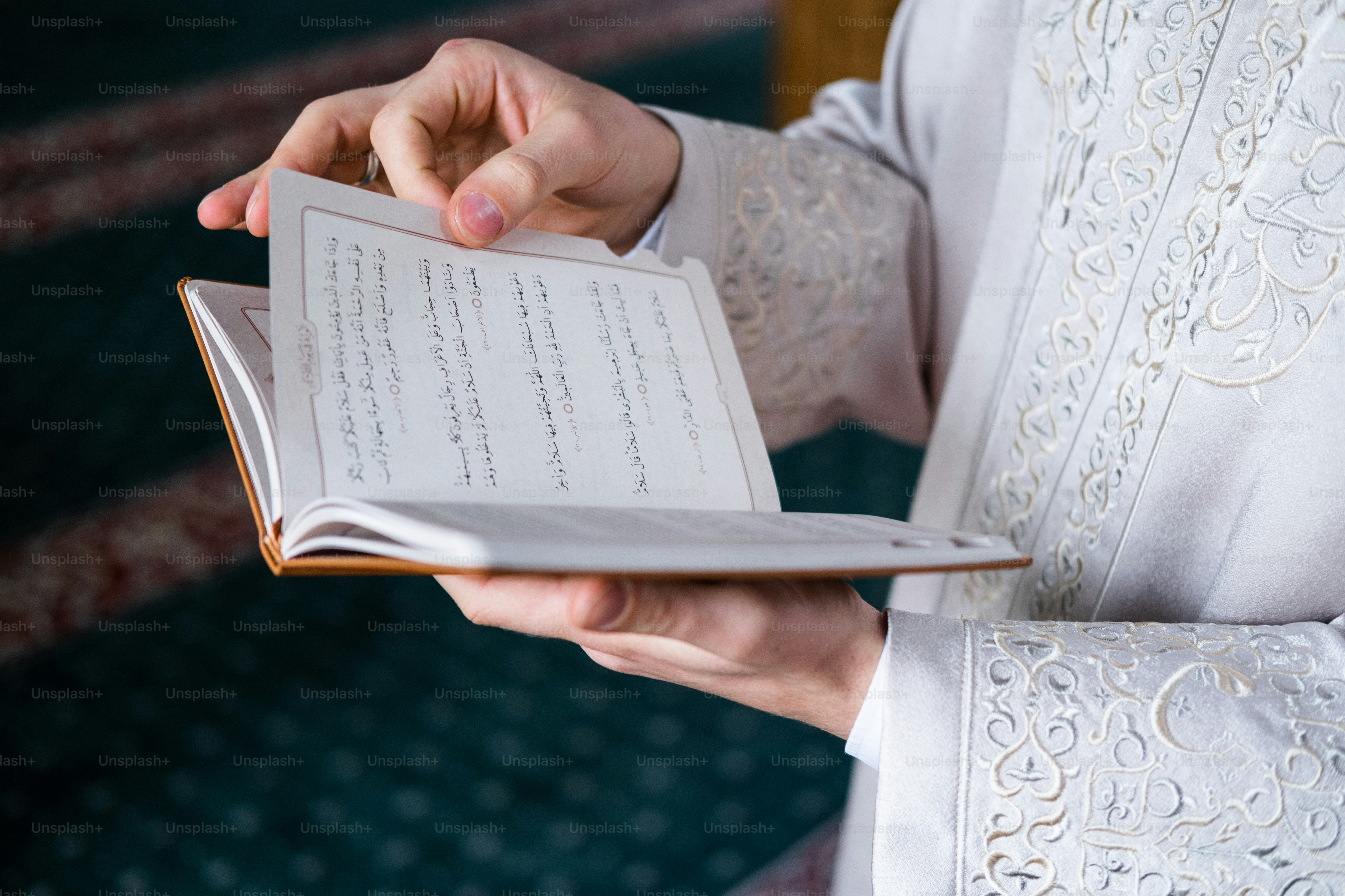 A woman holding a book in her hands photo – Islamic calligraphy Image ...