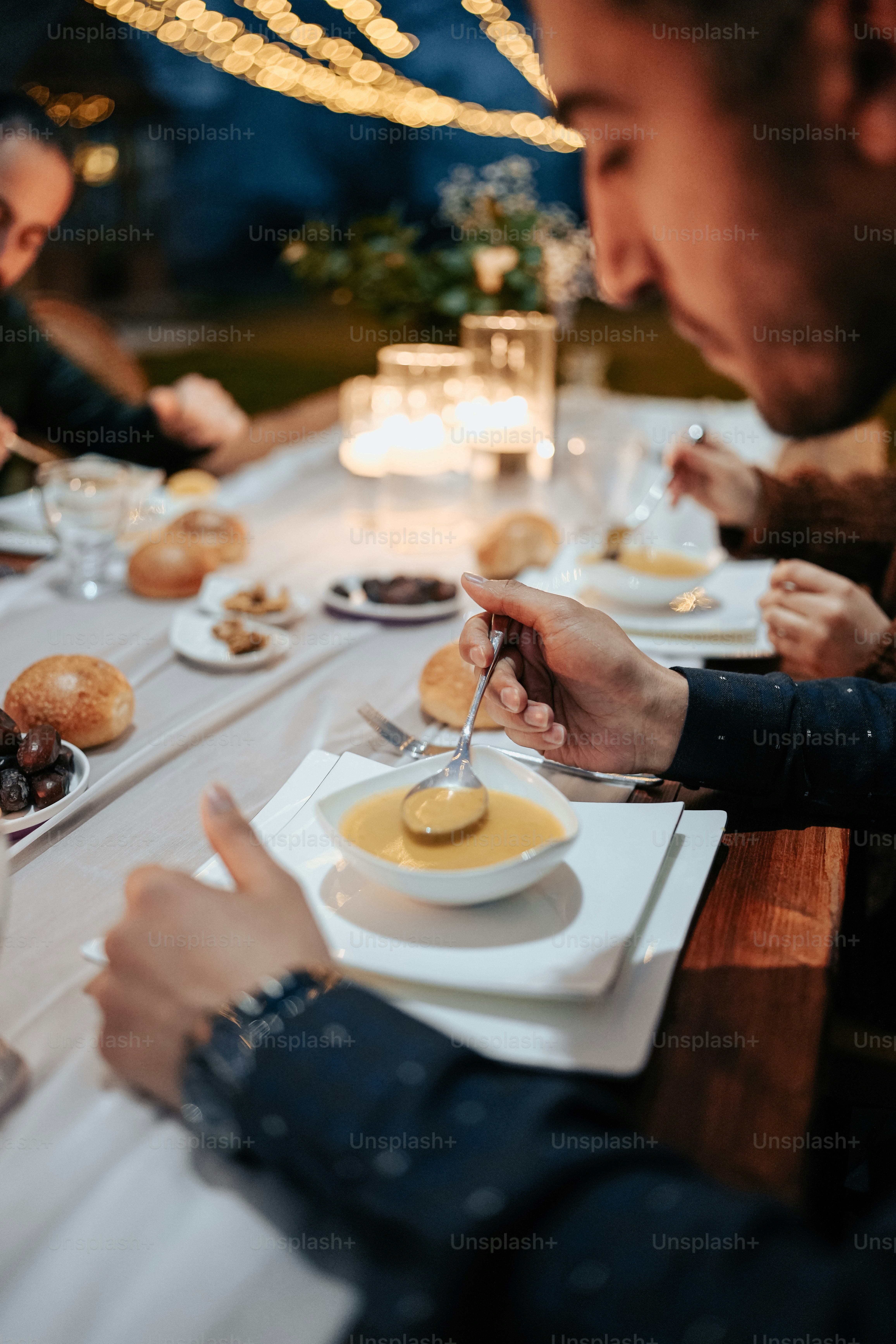 Un groupe de personnes assises autour d’une table en train de manger de ...
