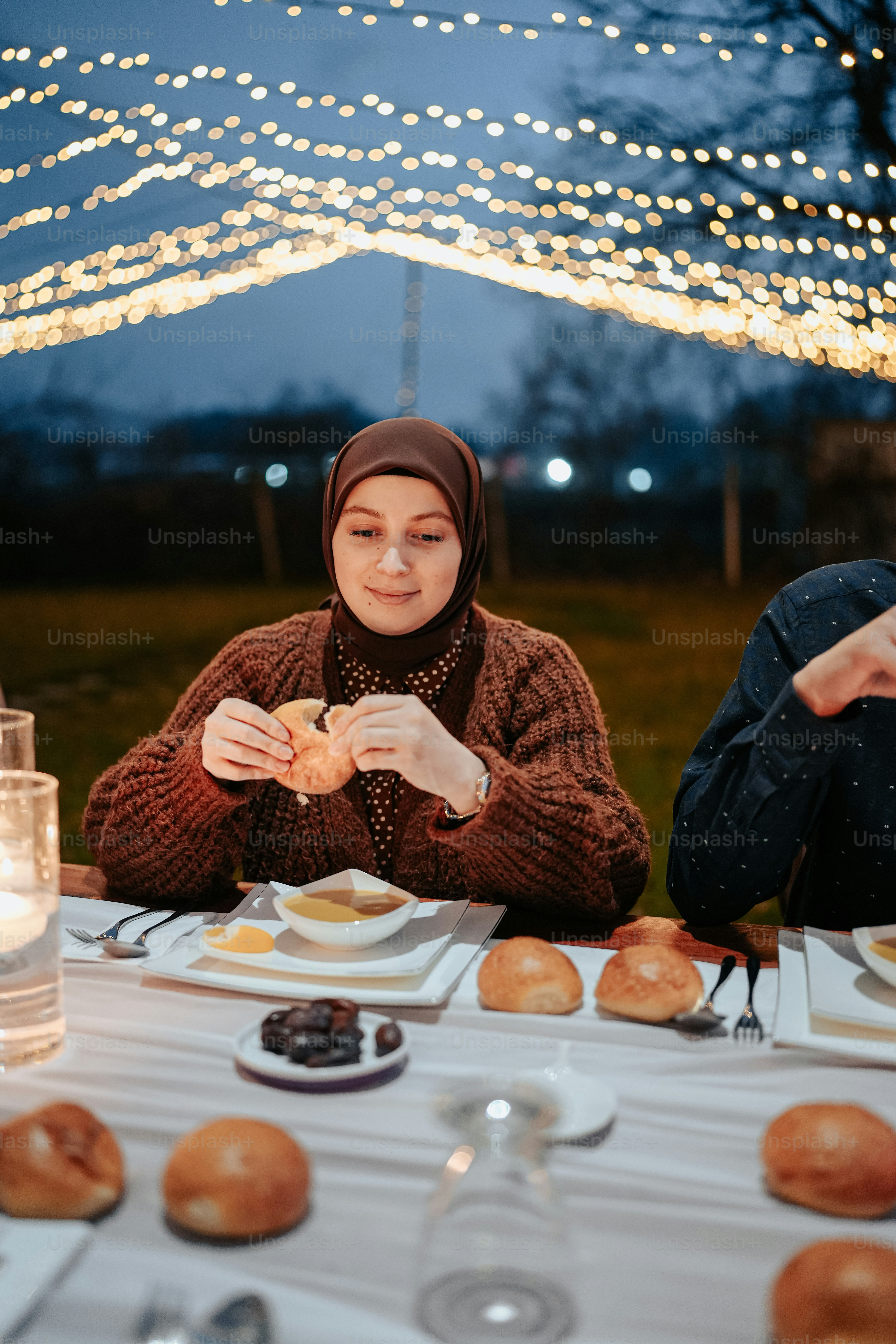 A woman sitting at a table eating a bagel photo – Woman Image on Unsplash