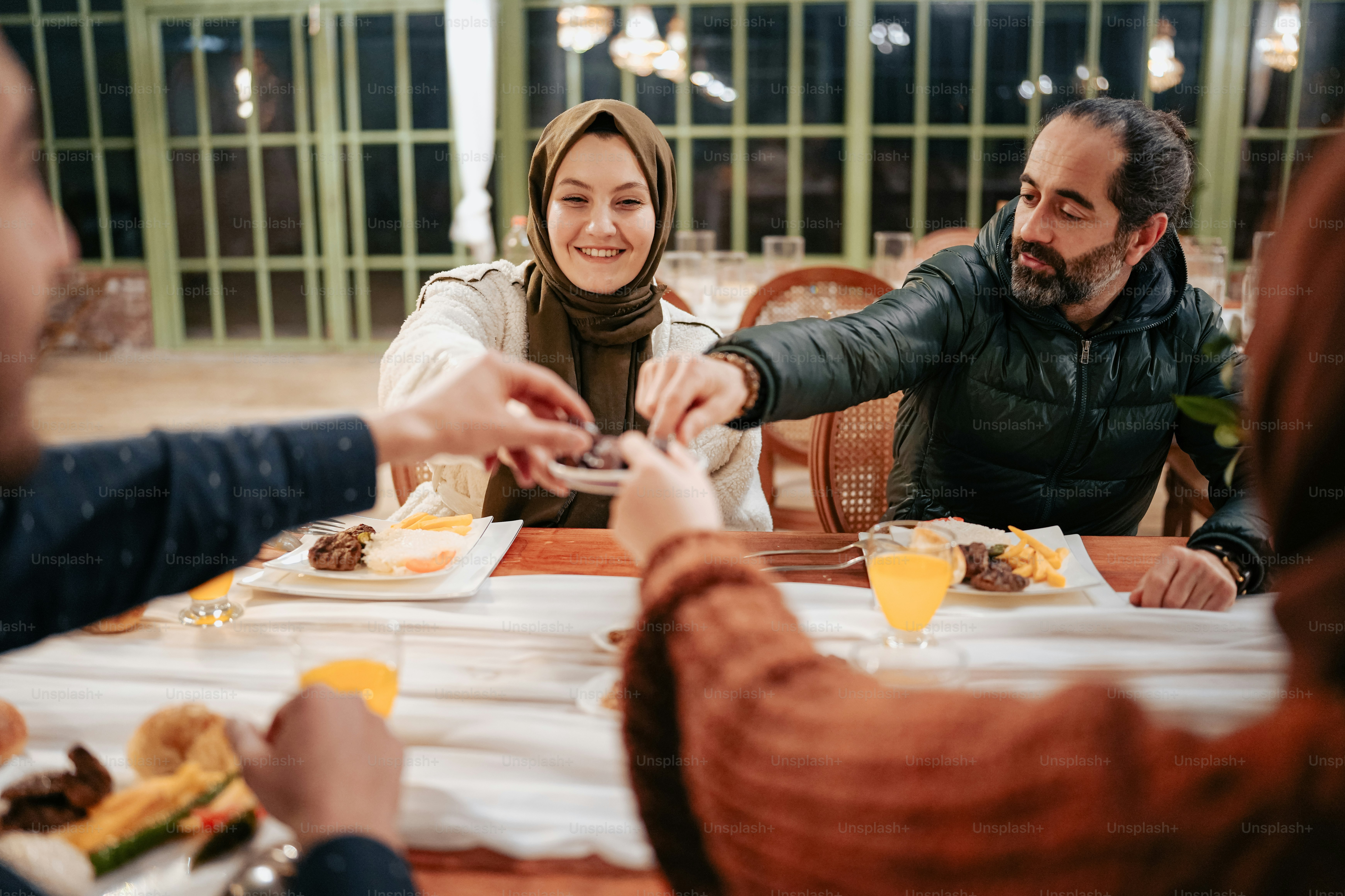 A group of people sitting around a wooden table photo – Family Image on ...