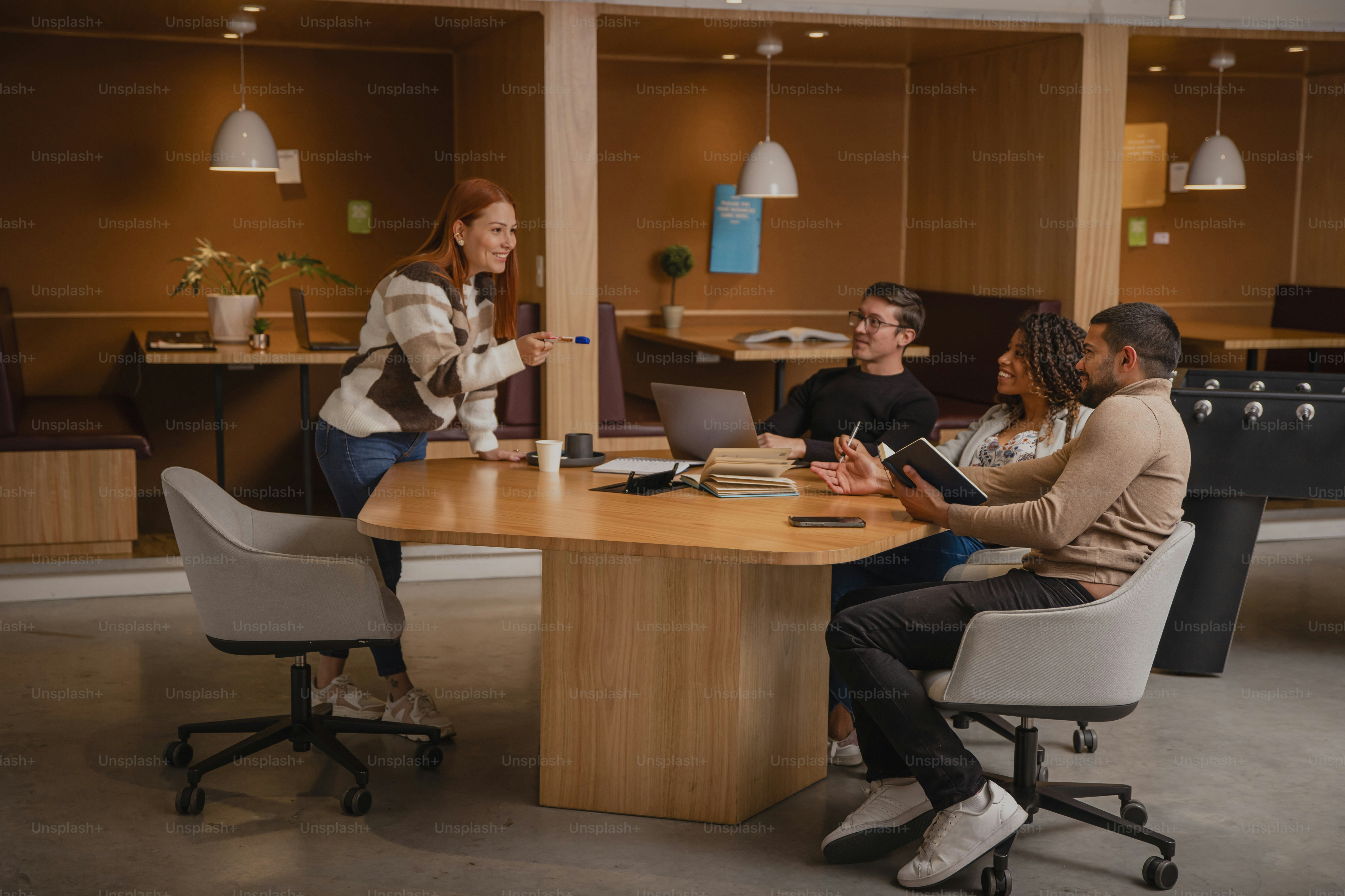 Un groupe de personnes assises autour d’une table en bois photo – Image ...