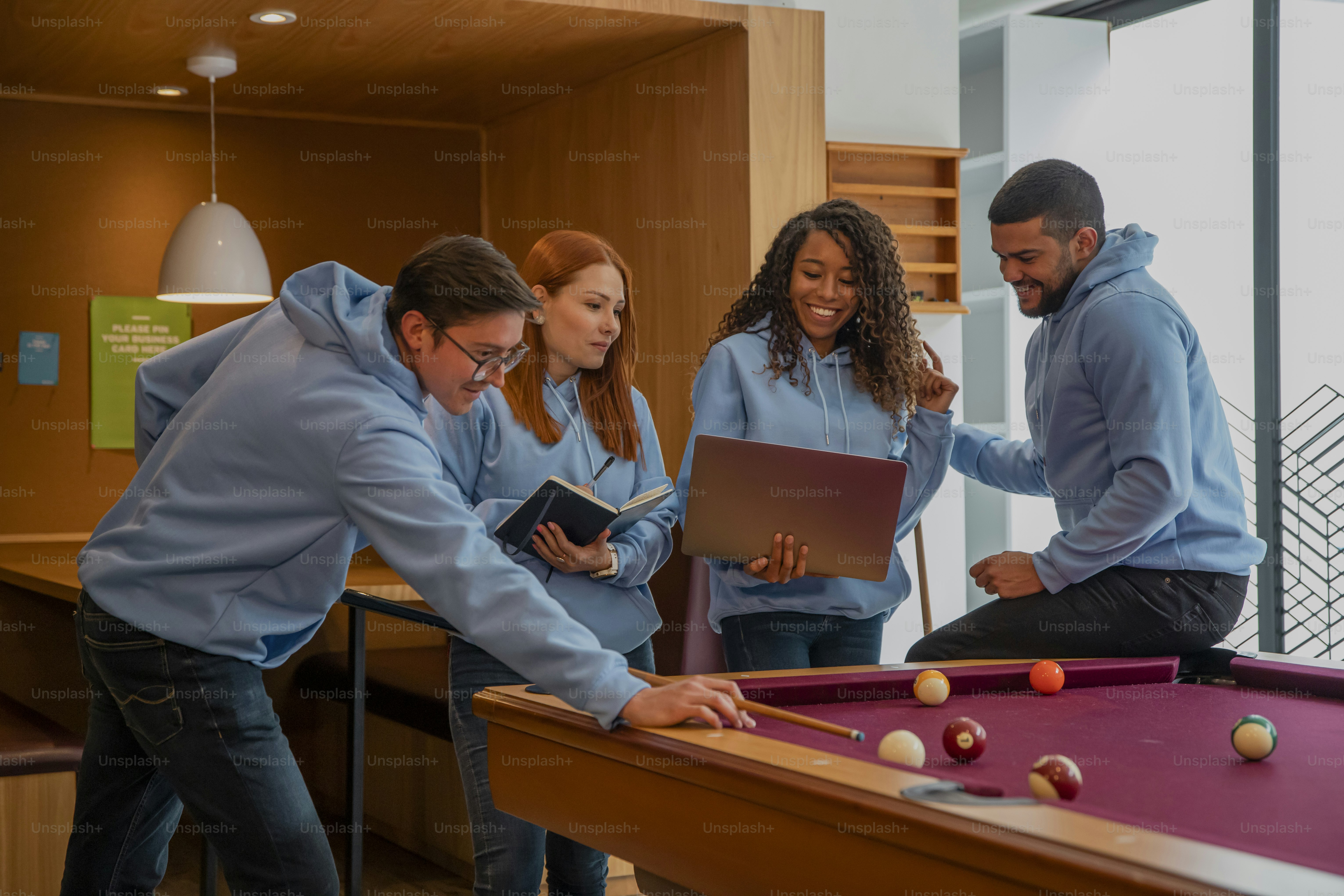 A group of people standing around a pool table photo – Cool office ...