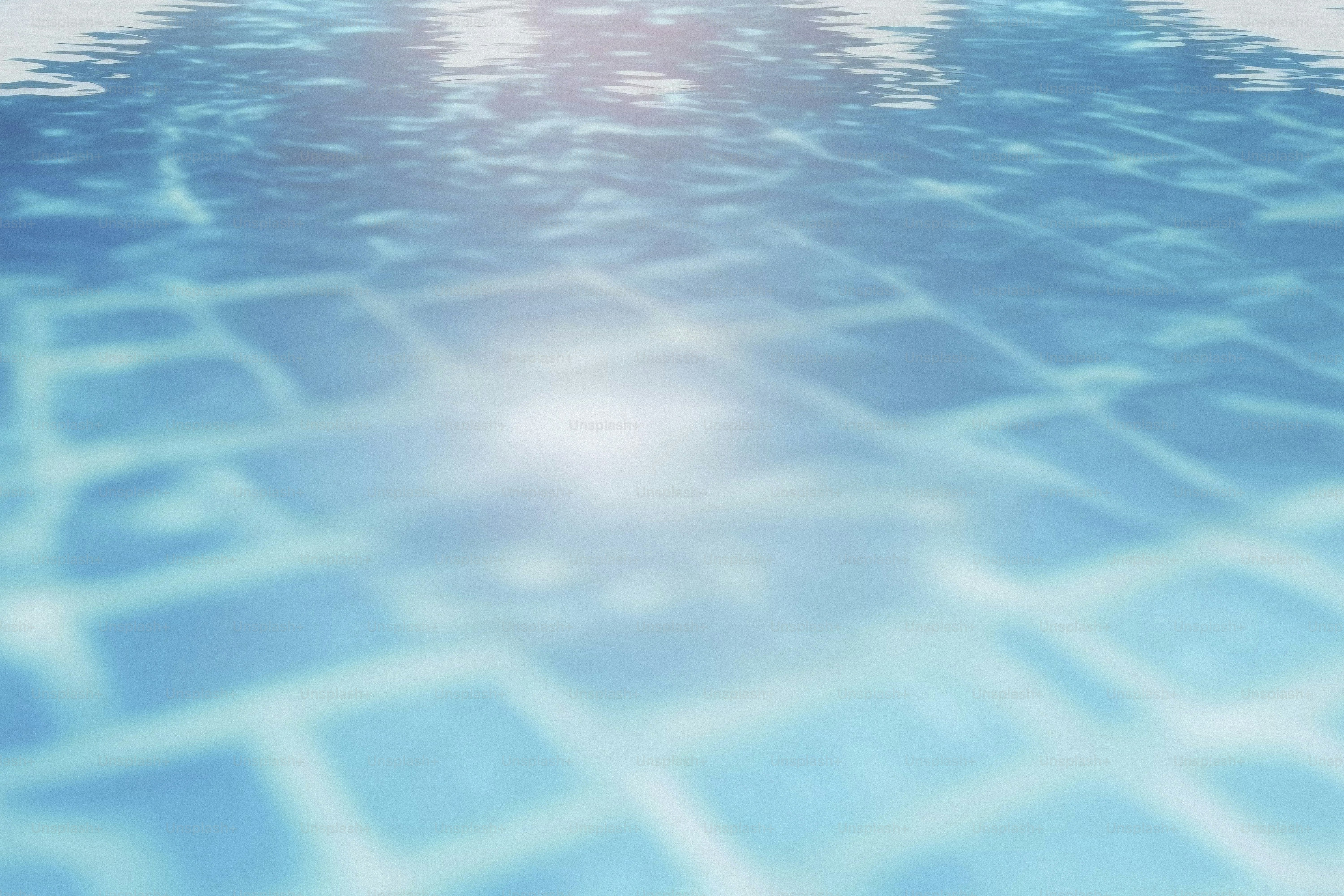 A blue swimming pool with the sun reflecting on the water photo ...