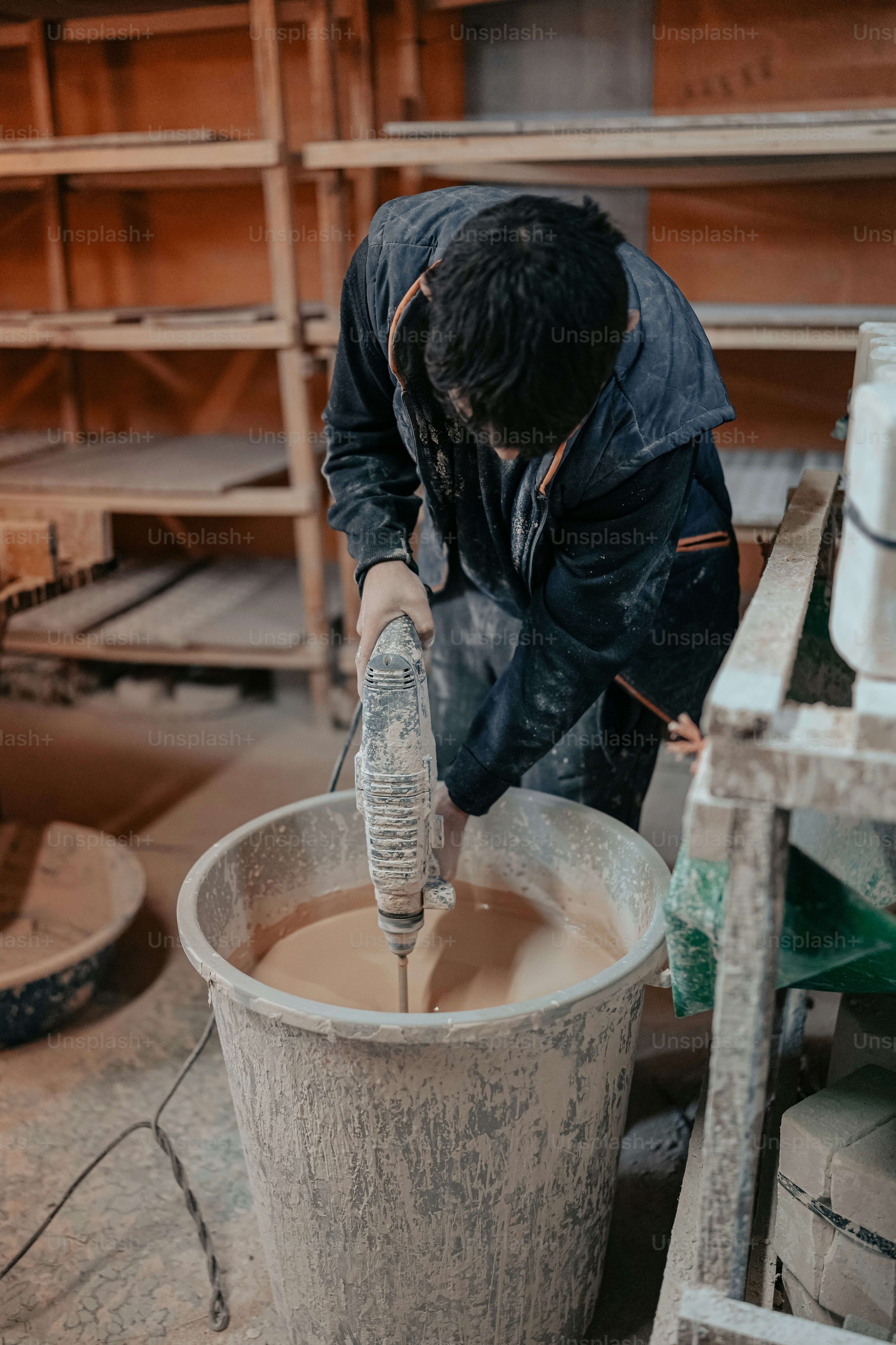 A man is pouring something into a bucket photo – Handmade Image on Unsplash