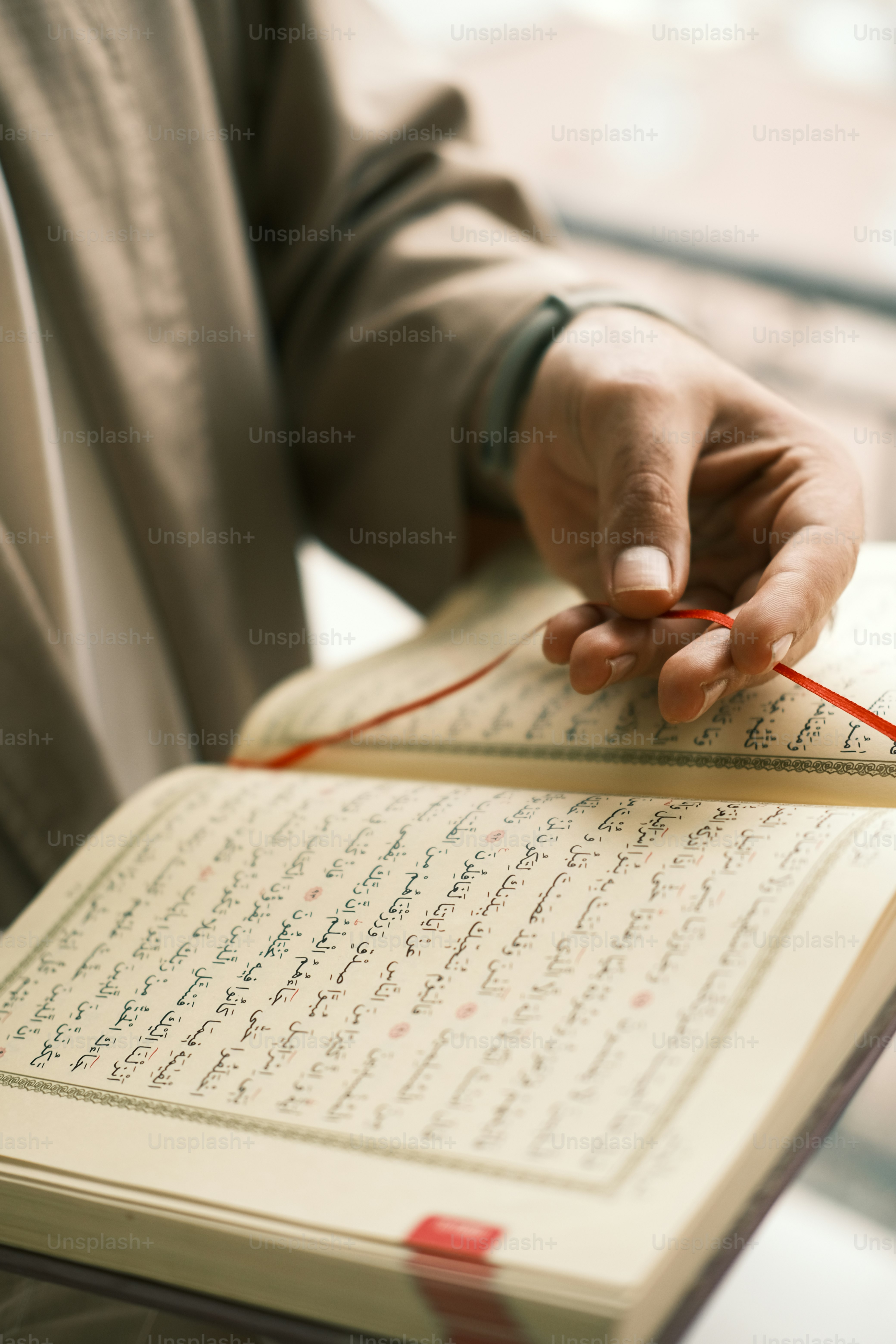 A person holding an open book with writing on it photo – Imam Image on ...