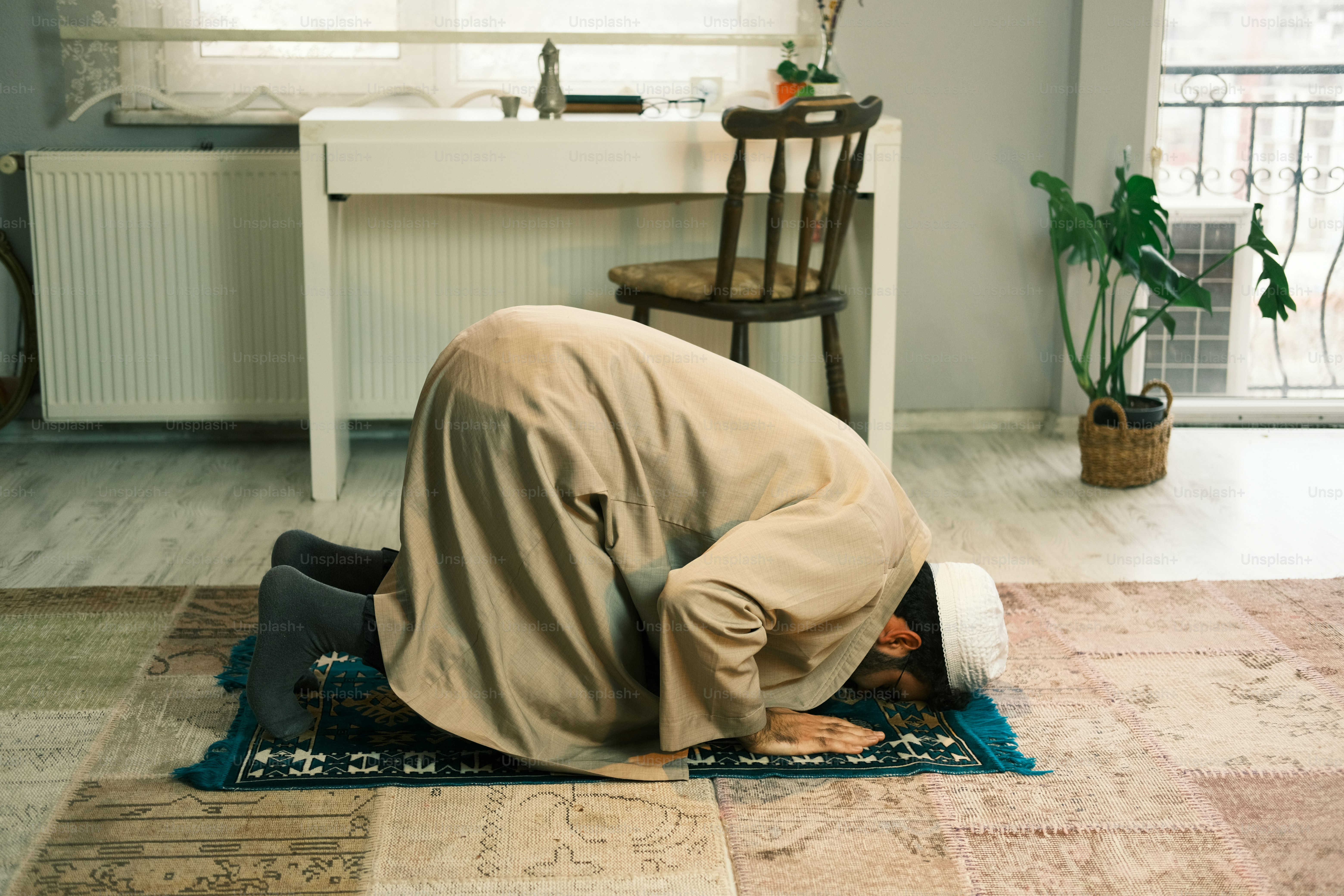 A man kneeling down on a rug in a room photo – Prayer rug Image on Unsplash