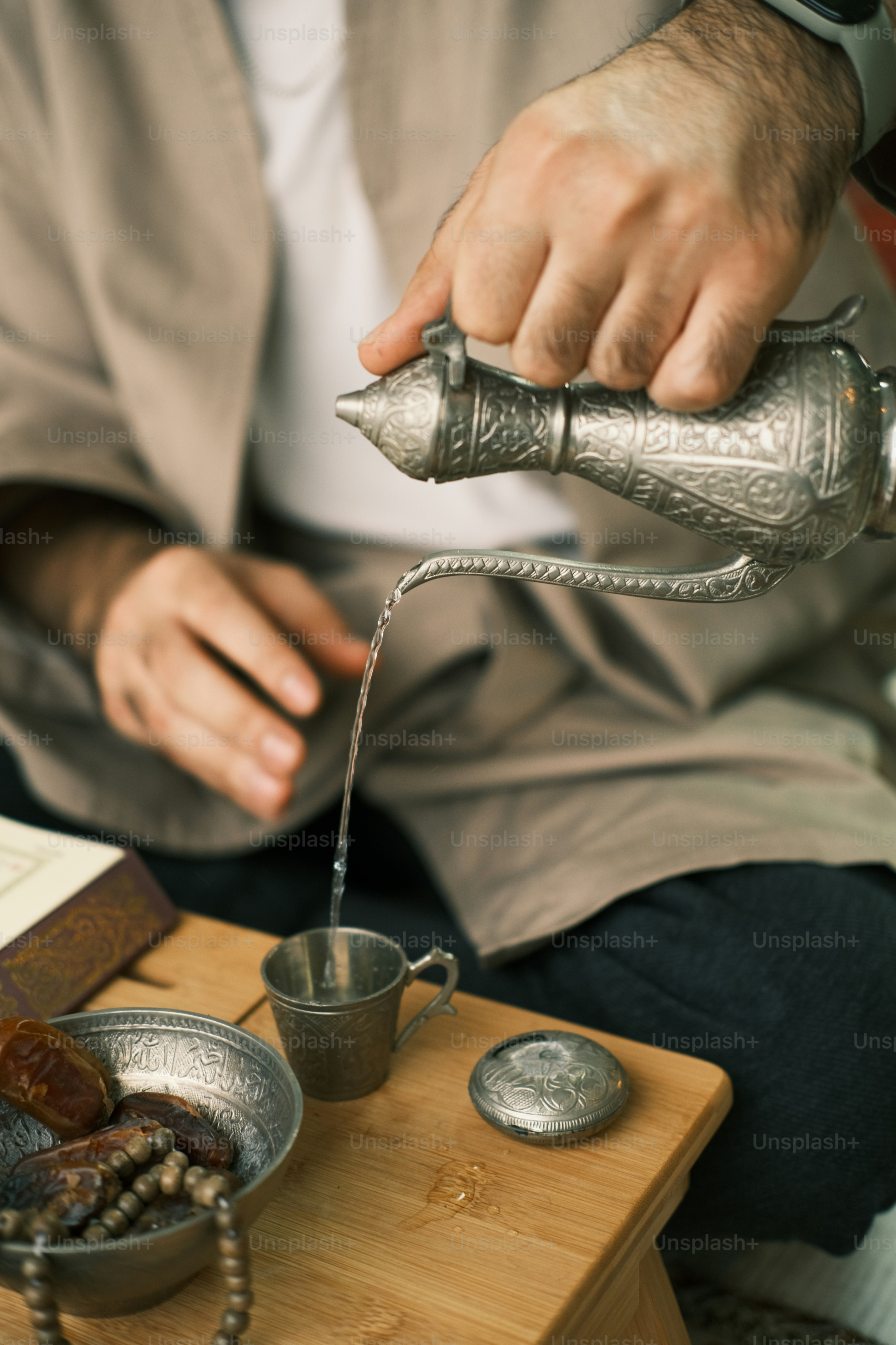 A man pouring water from a teapot into a cup photo – Eid Image on Unsplash