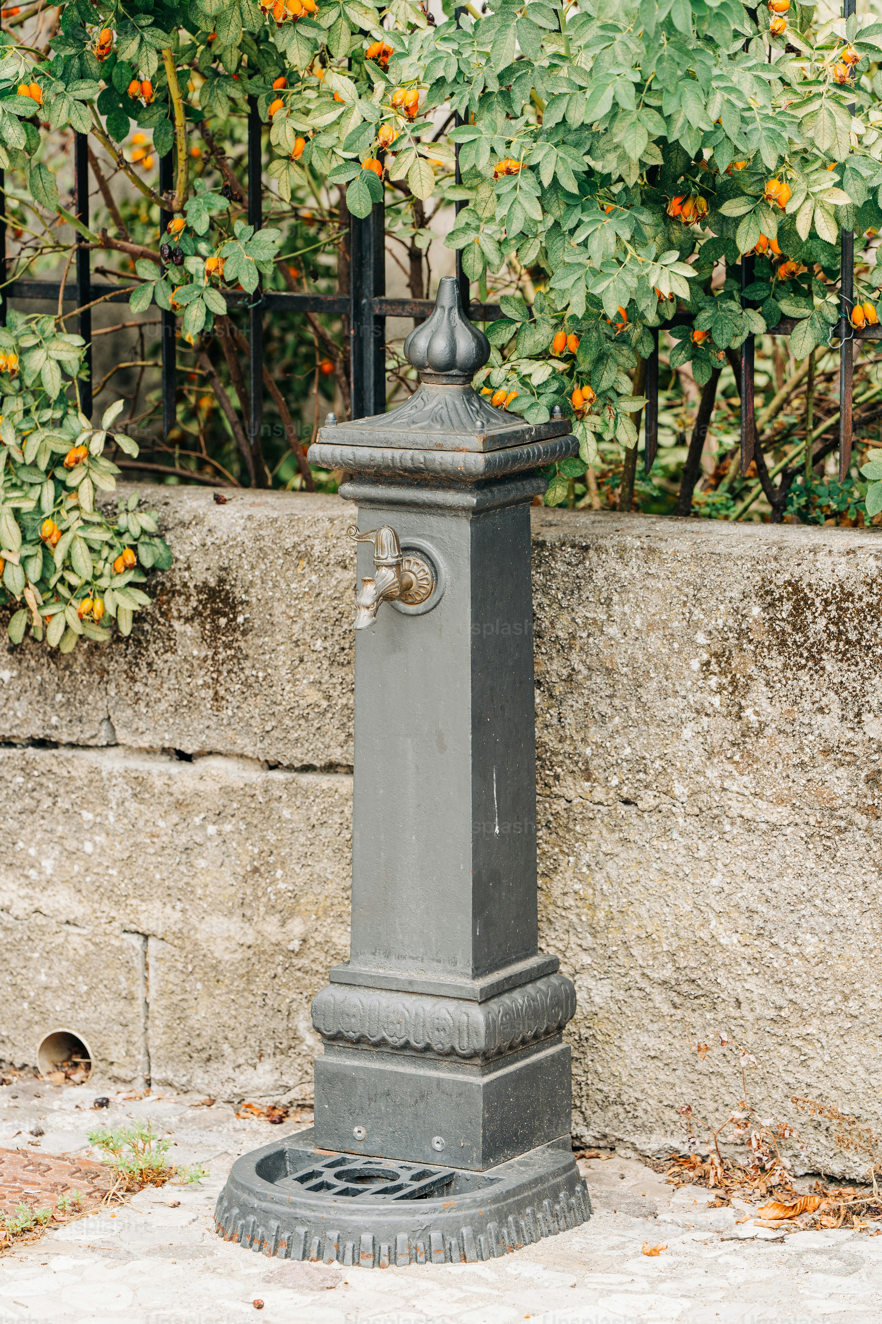 A gray fire hydrant sitting on the side of a road photo – Water ...