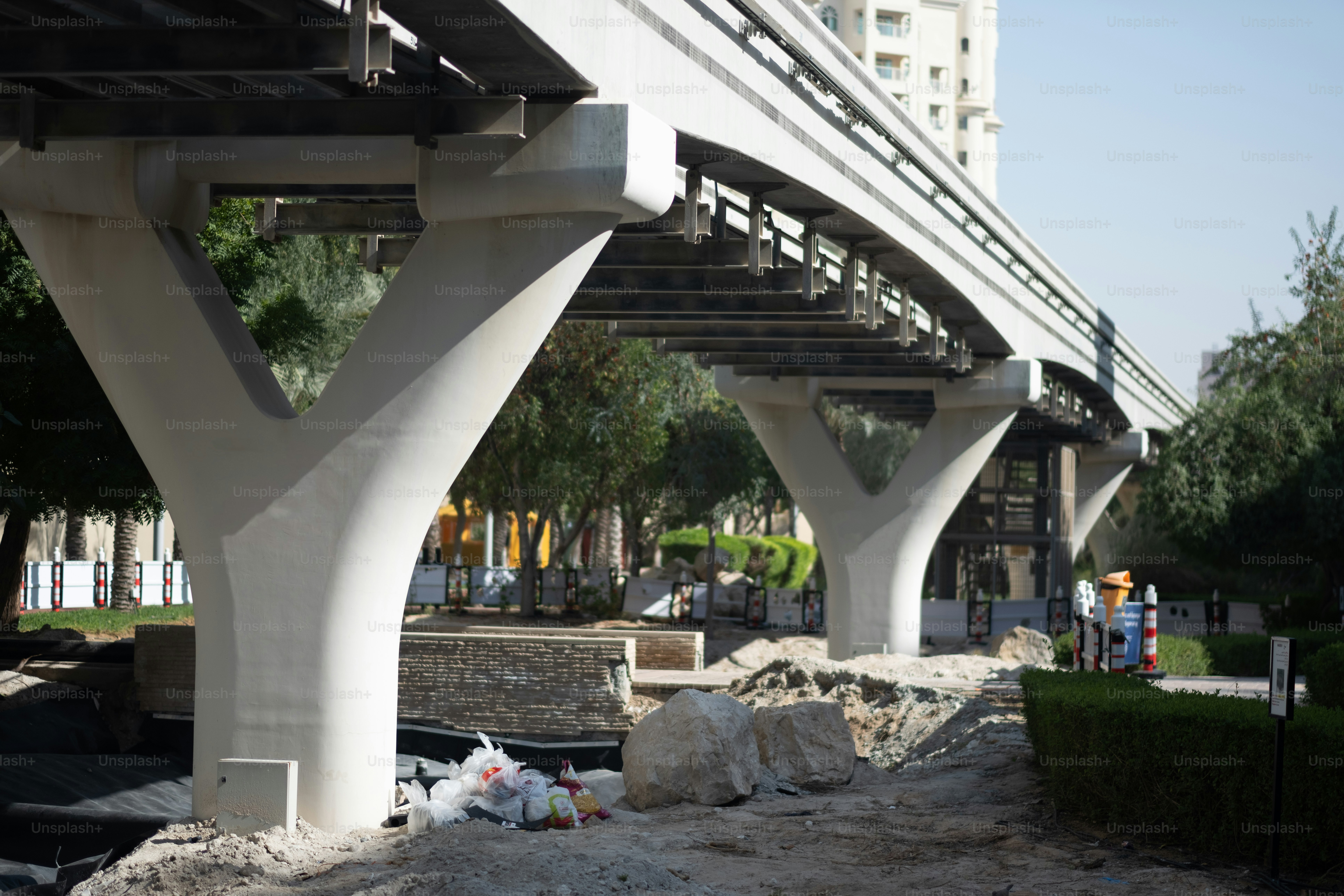 A bridge over a road with a bunch of trash on the ground photo – Green ...