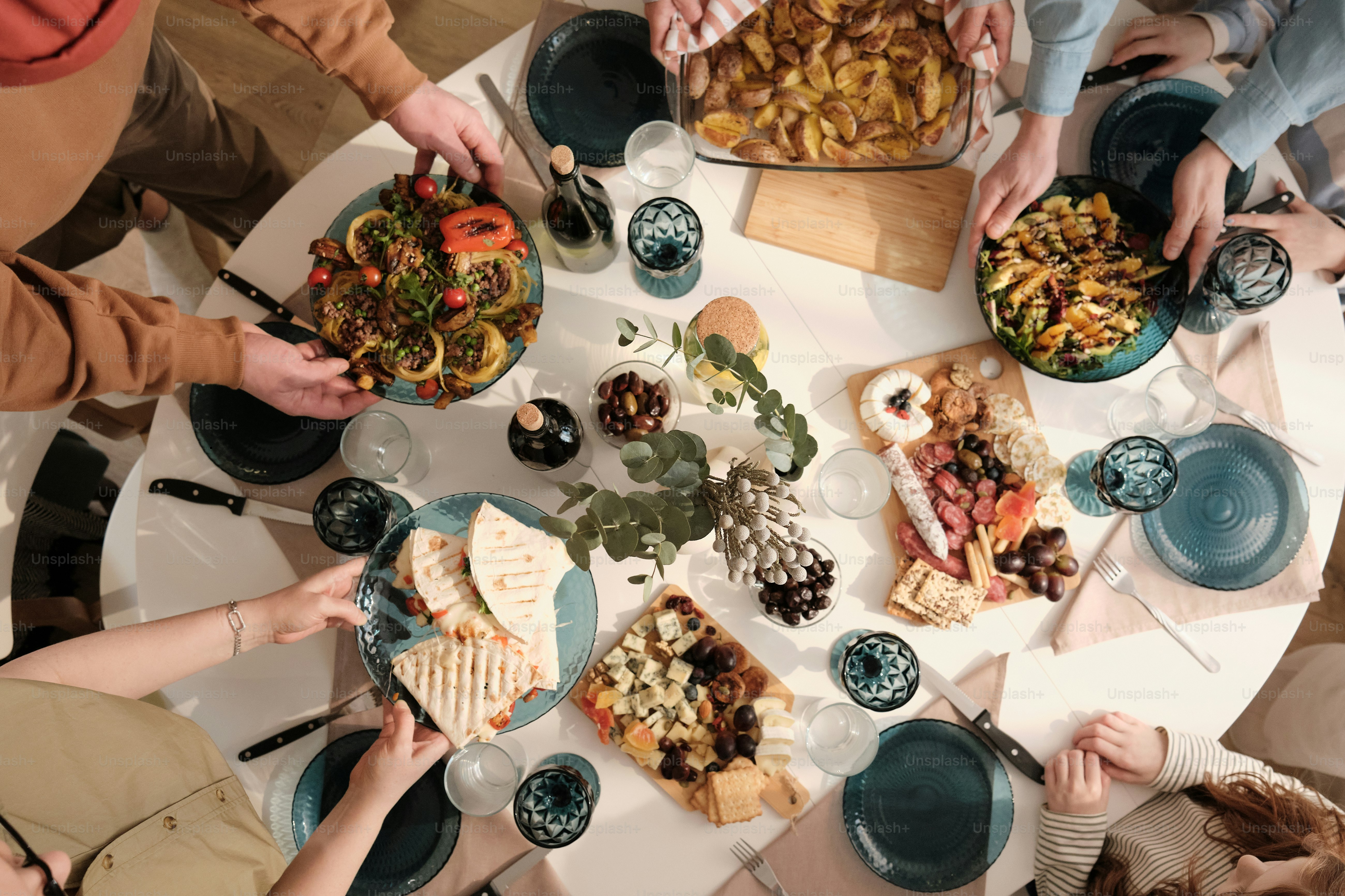 A group of people sitting around a table with plates of food photo ...