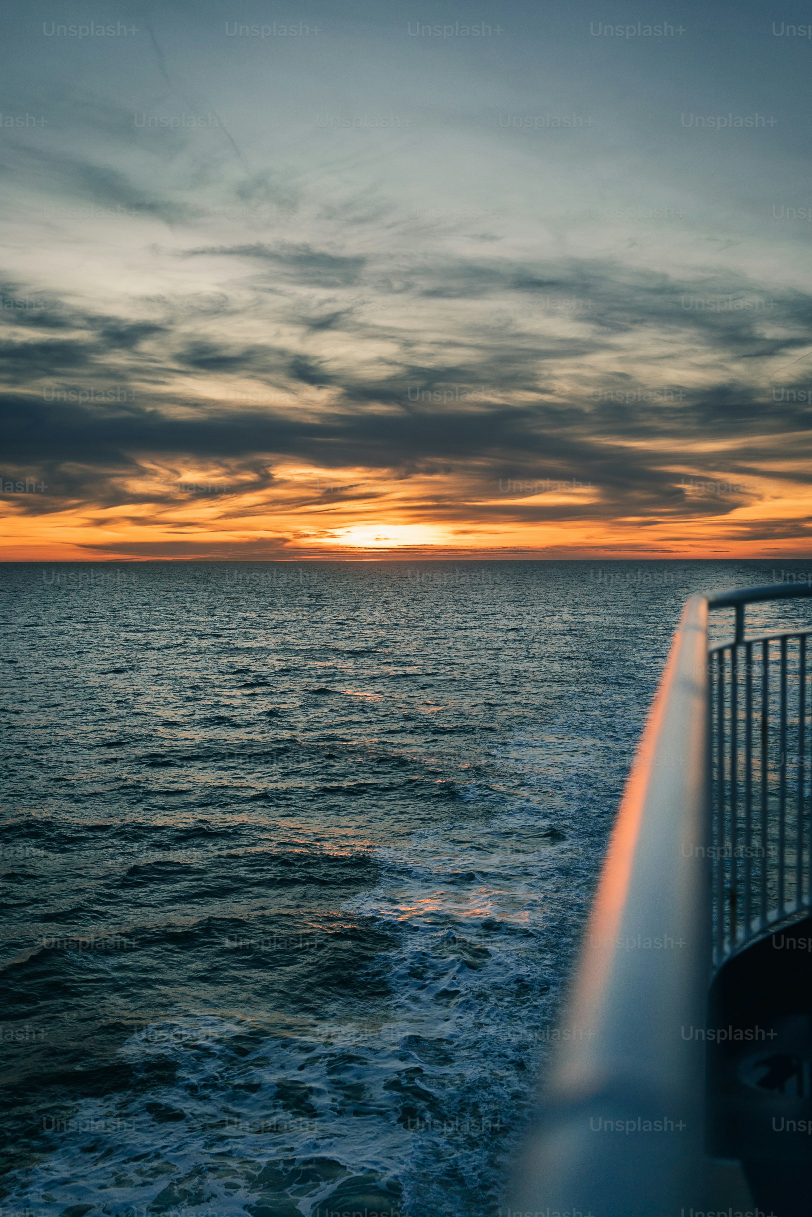 The sun is setting over the ocean as seen from a boat photo – Travel ...