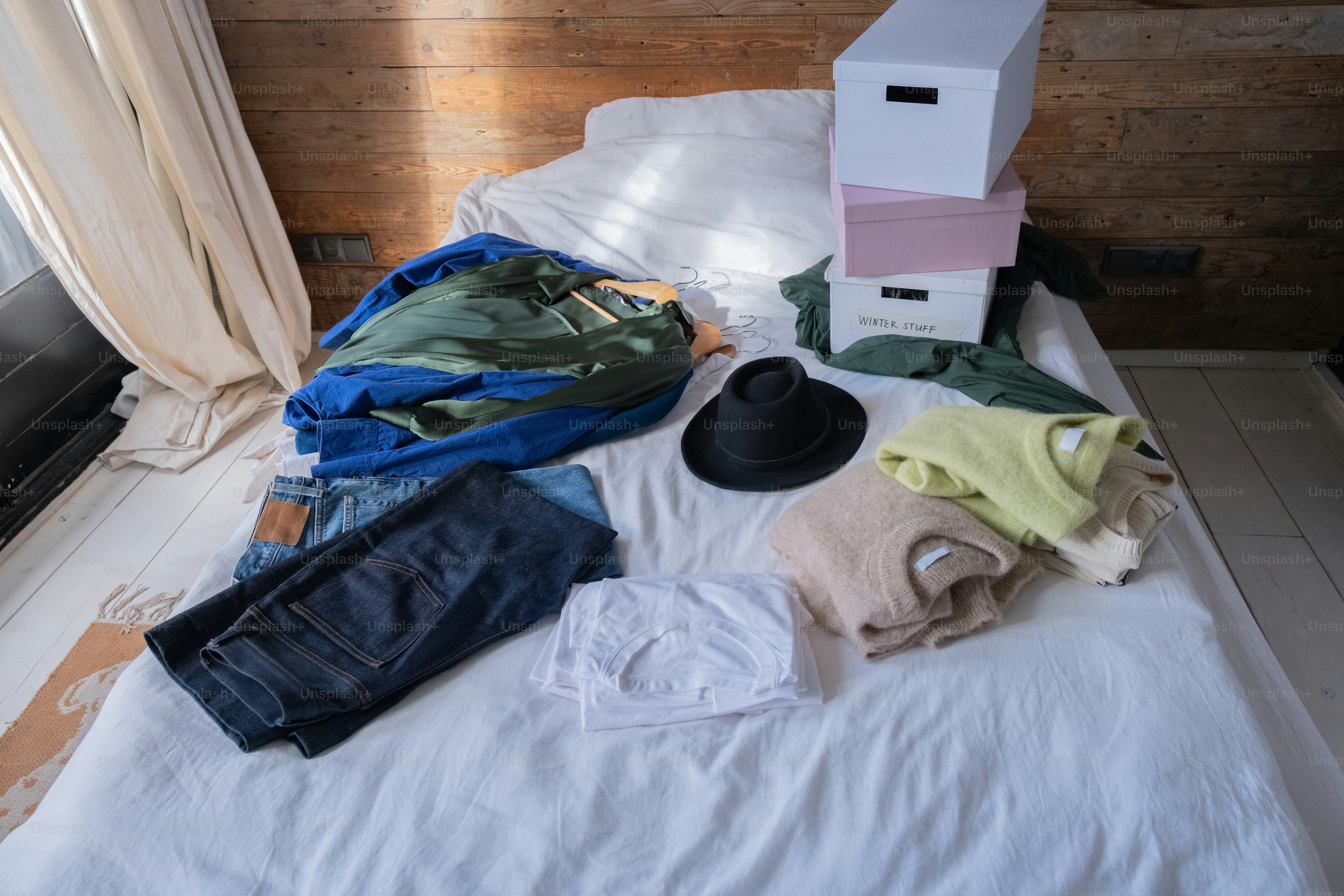 Un montón de ropa sentada encima de una cama foto – Imagen de ...