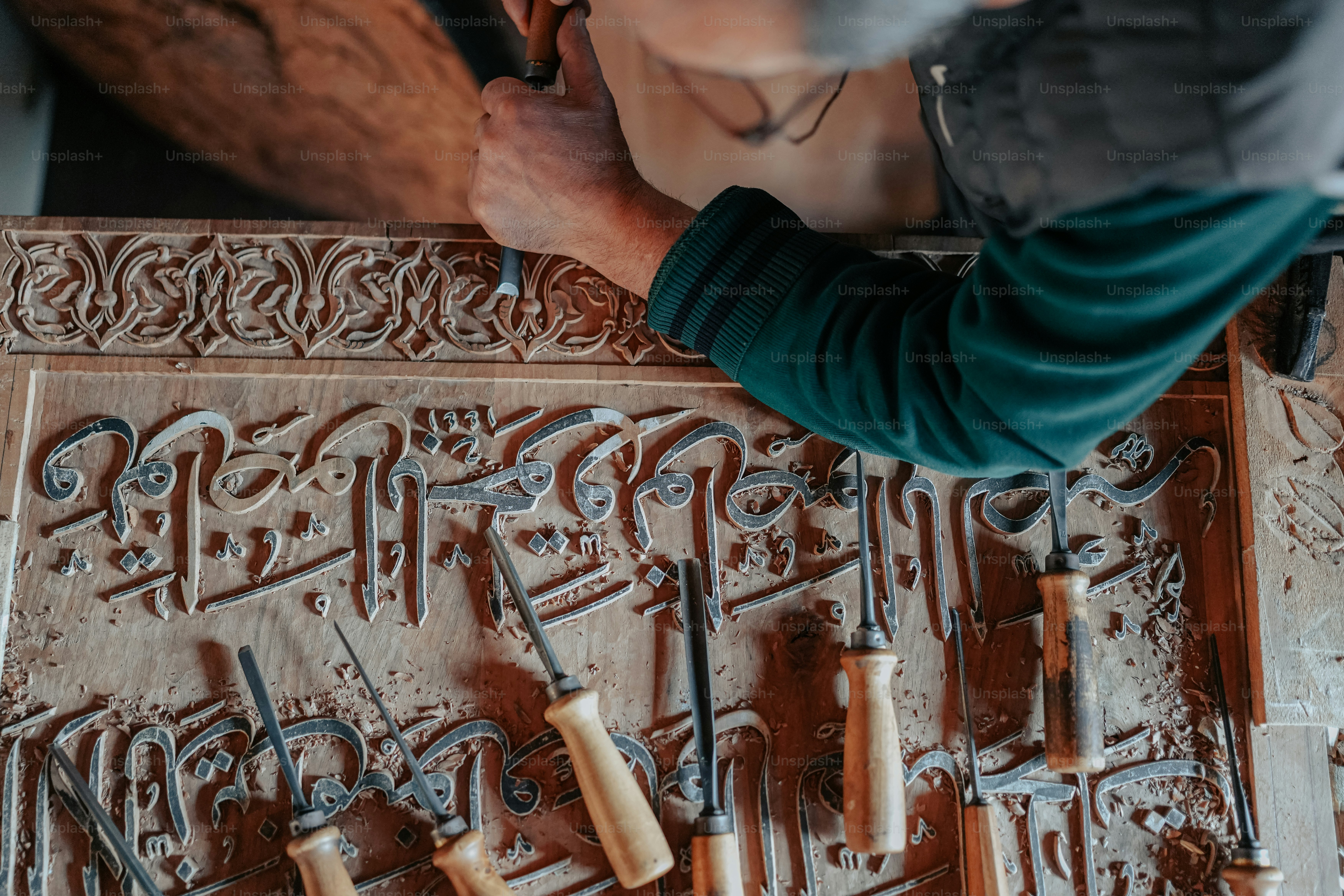 A man working on a carving on a wall photo – Hand made Image on Unsplash