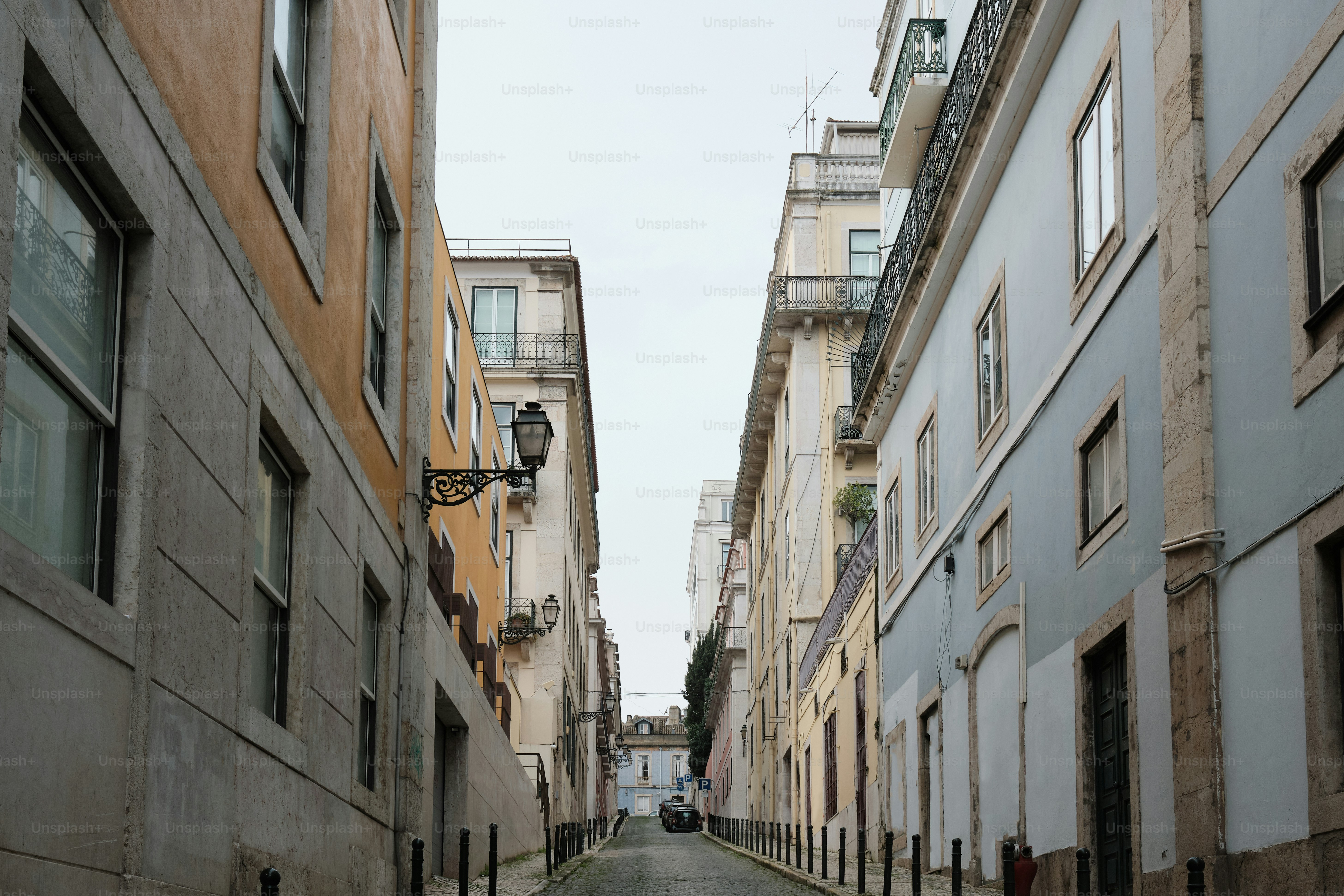 A narrow city street lined with tall buildings photo – Lisbon Image on ...