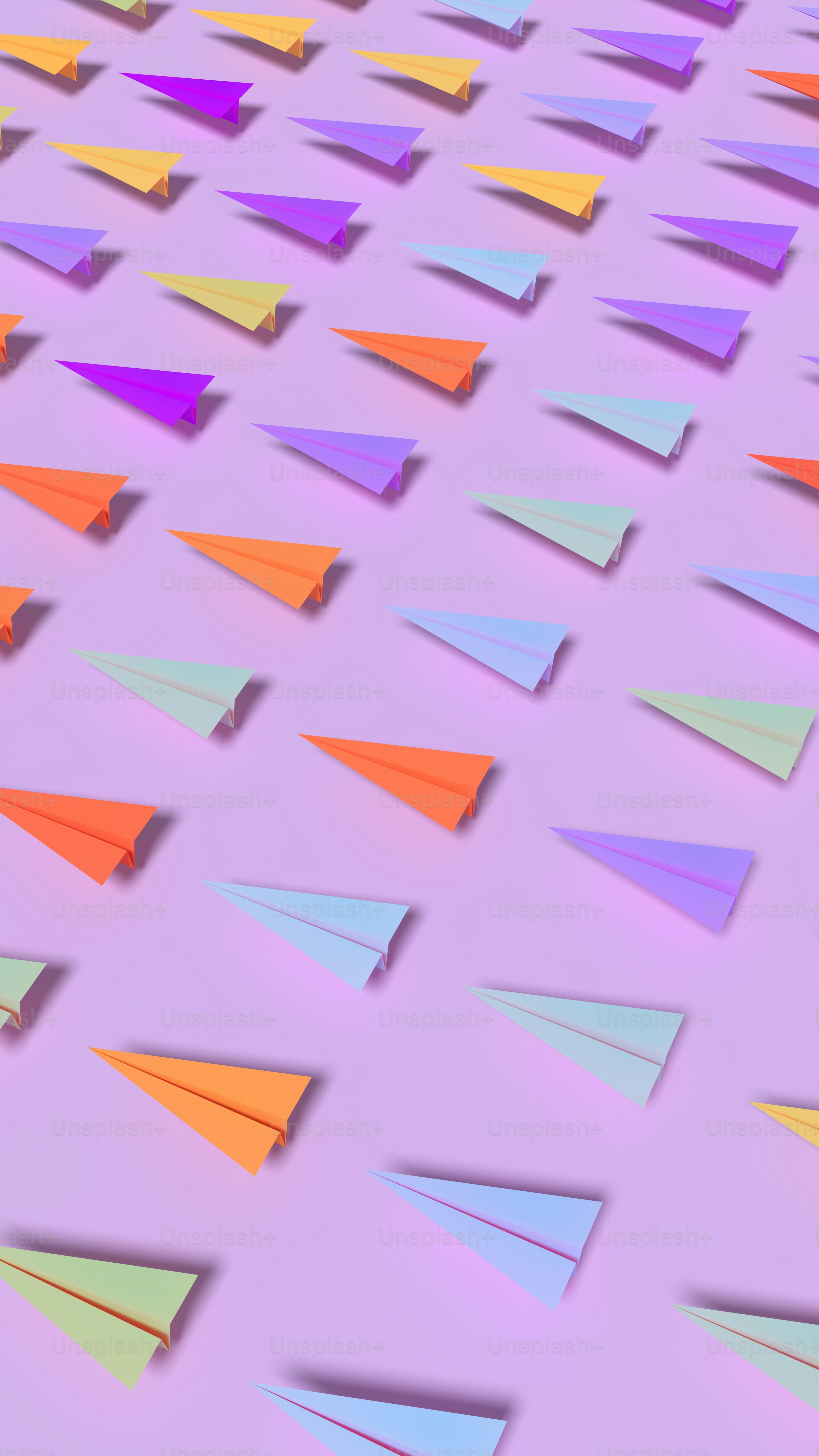 A group of colorful paper airplanes on a purple background photo ...