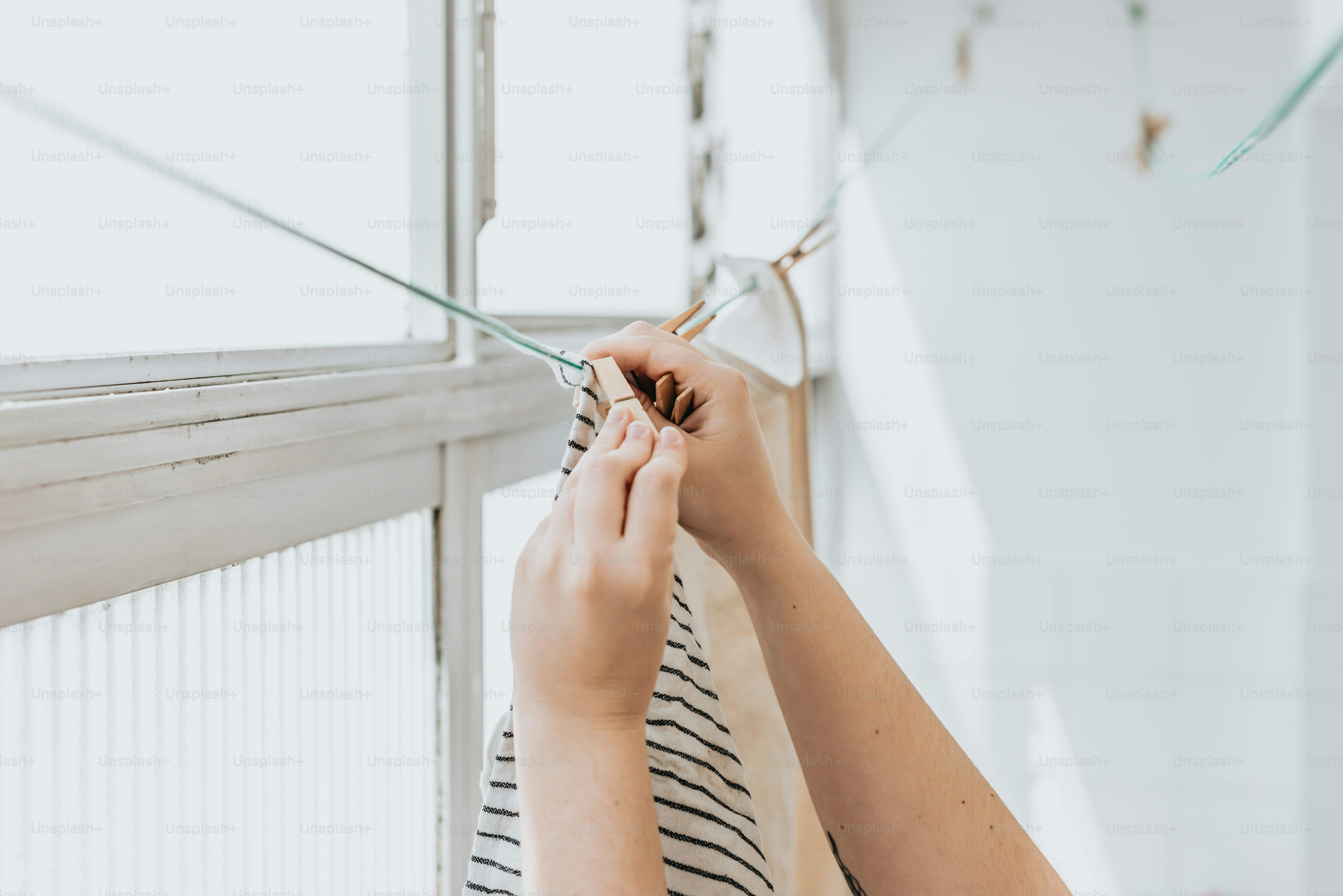 A person holding a pair of scissors near a window photo – Cleaning ...
