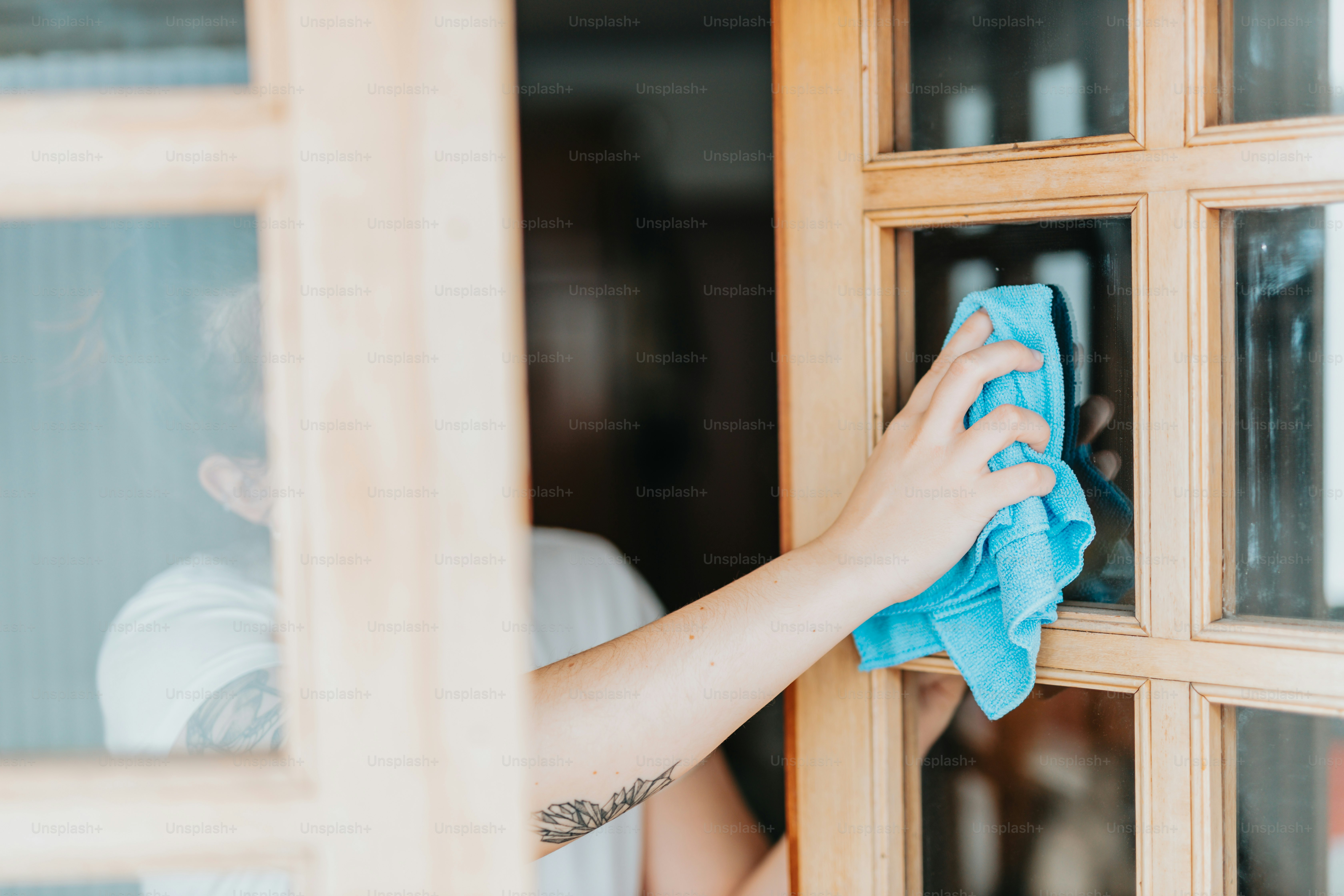 A person wiping up a window with a cloth photo – Cleaning up Image on ...