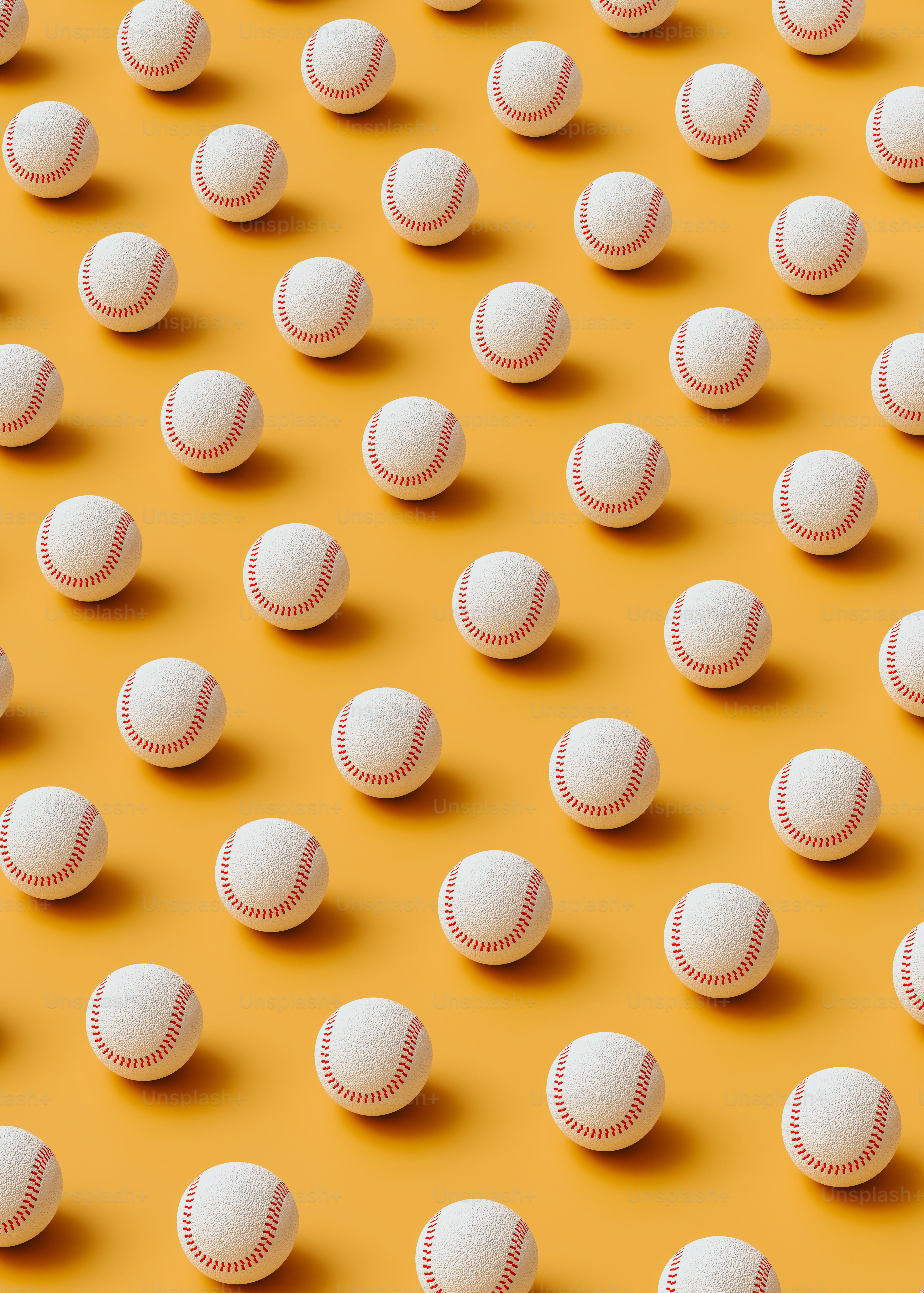 A group of white baseballs sitting on top of a yellow surface photo ...