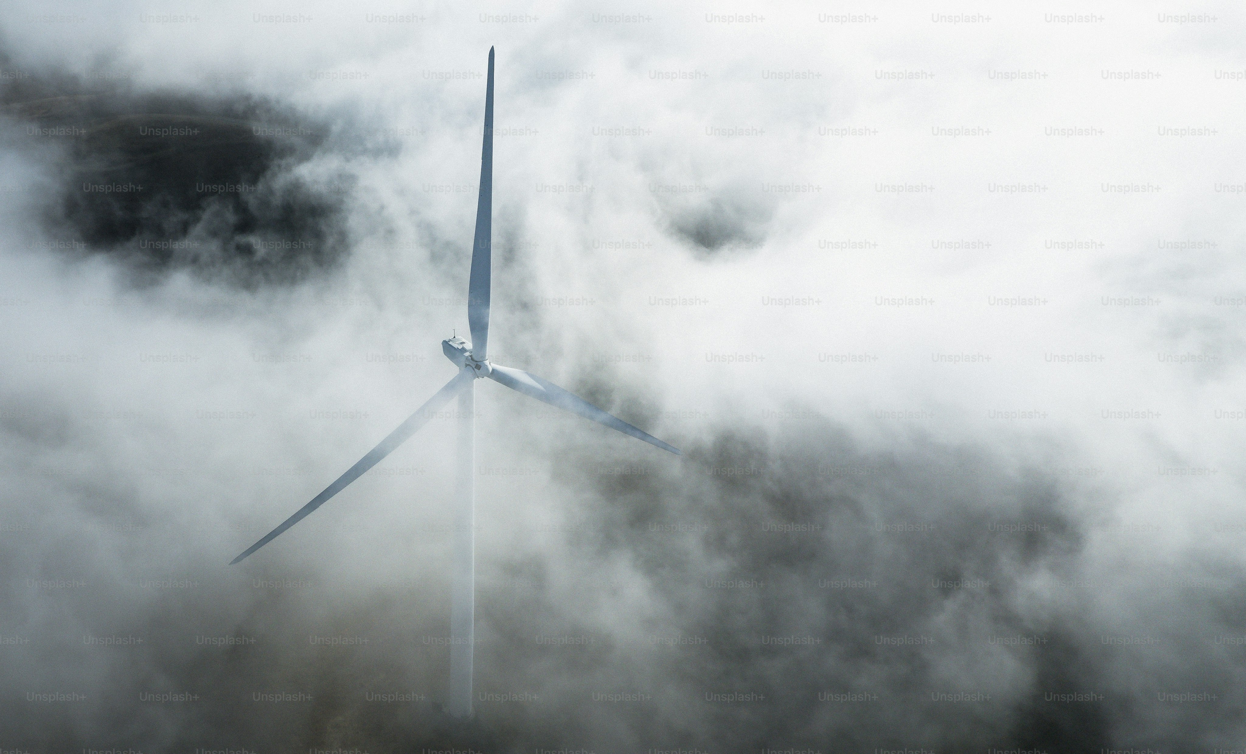 A wind turbine in the middle of a cloud filled sky photo – Wind energy ...