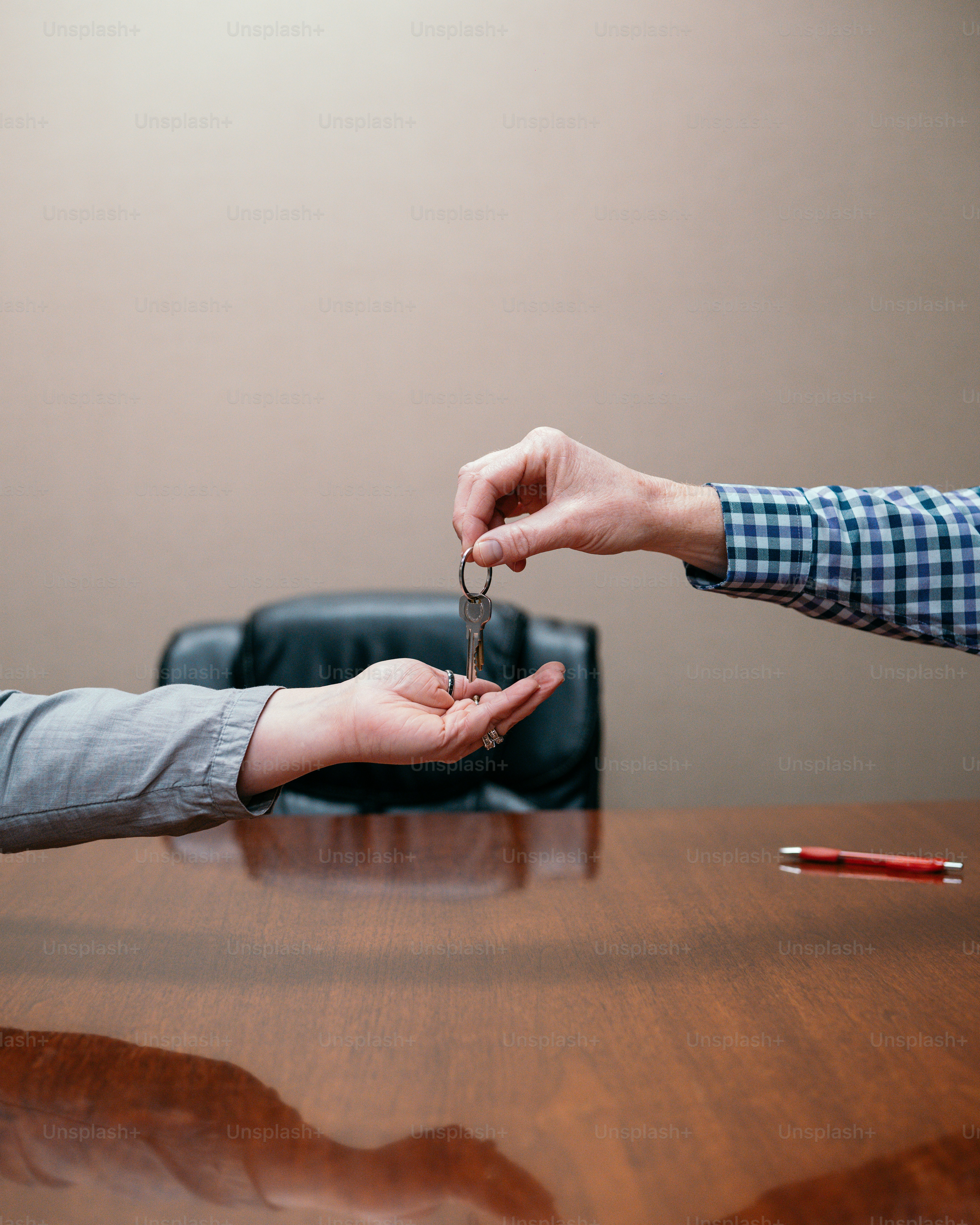 Two people exchanging keys to each other at a table photo – Home Image ...