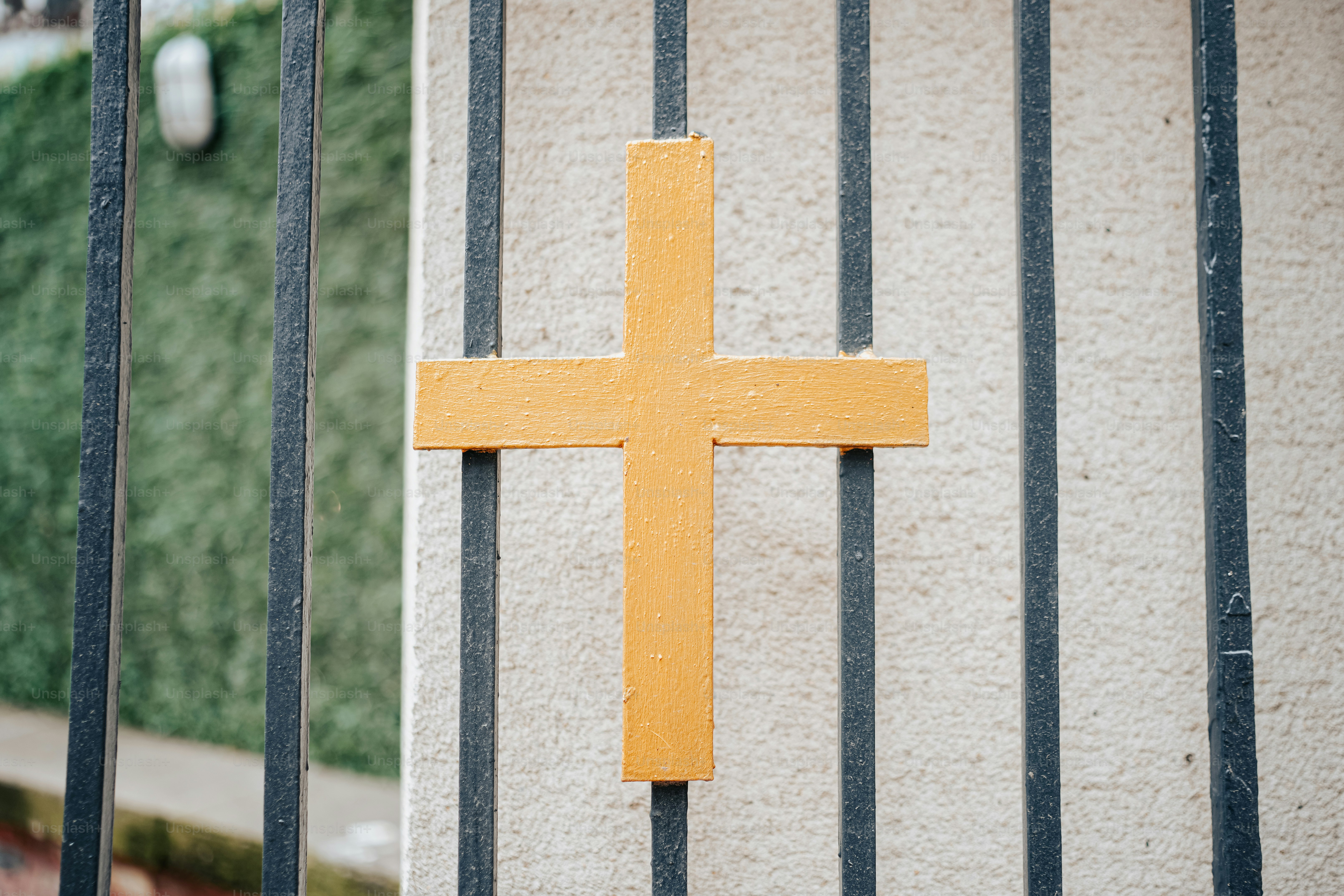 A yellow cross on the side of a building photo – The cross Image on ...