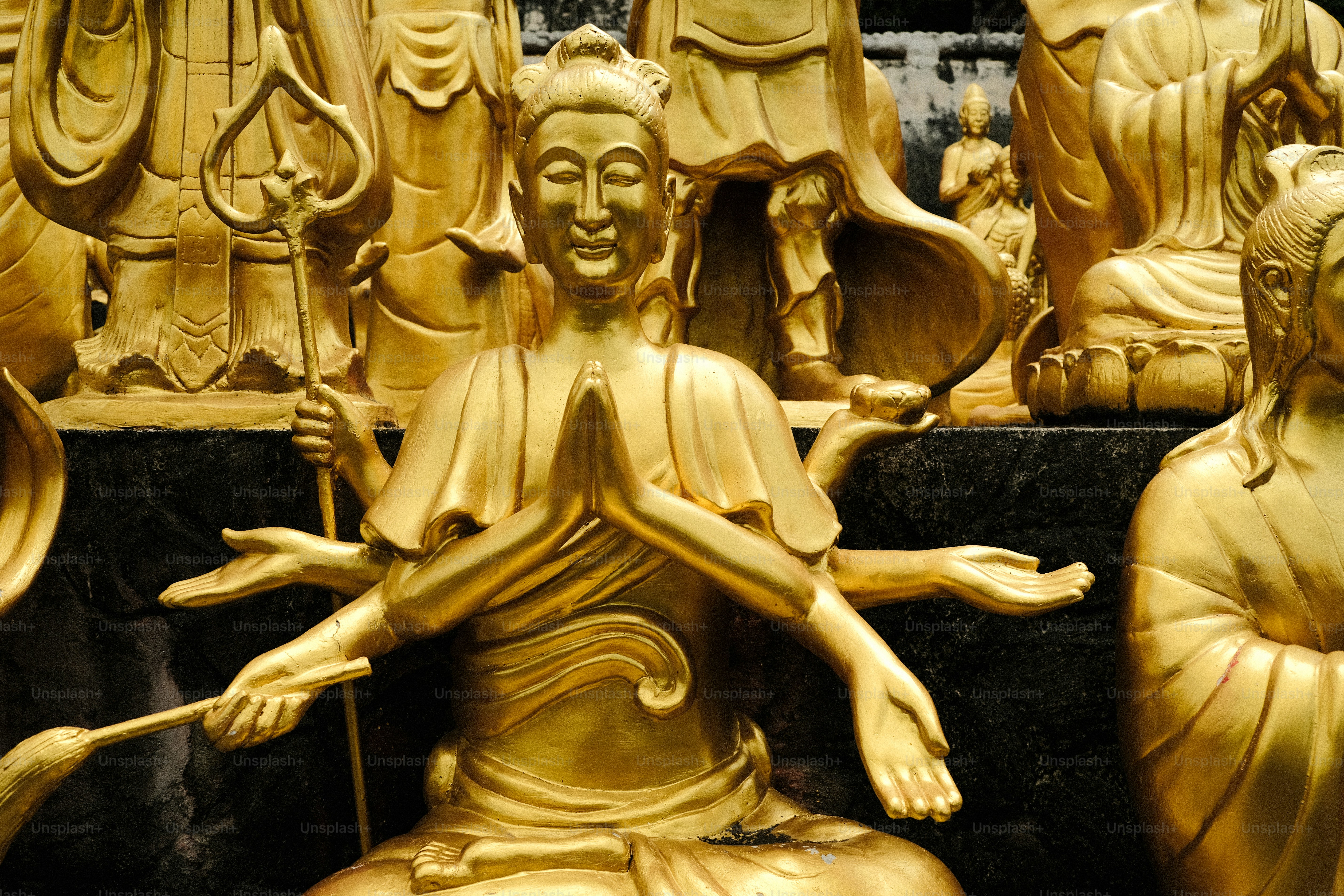 A statue of buddha surrounded by other statues photo – Gold Image on ...