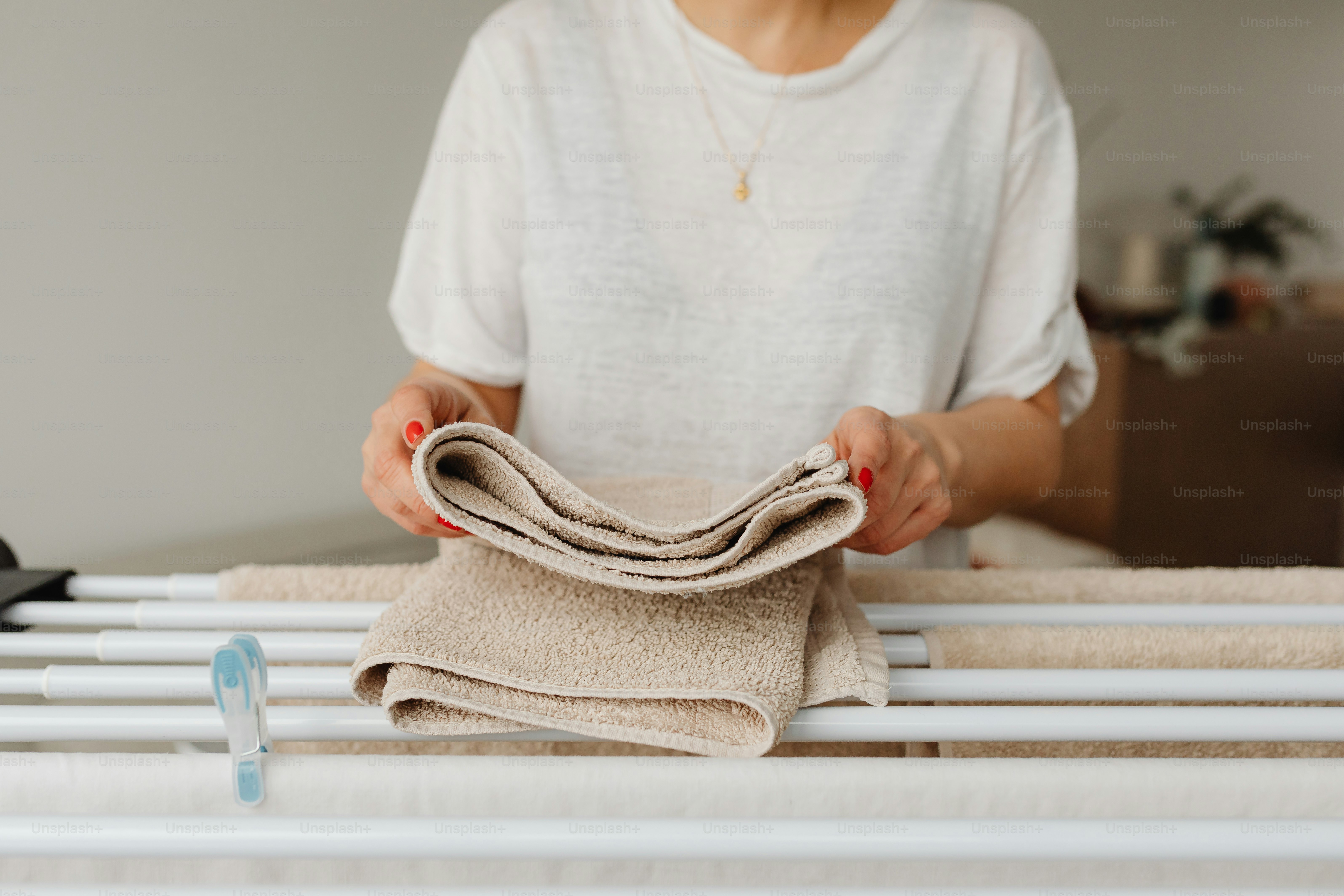 A woman holding a cloth over a bed rail photo – Laundry Image on Unsplash