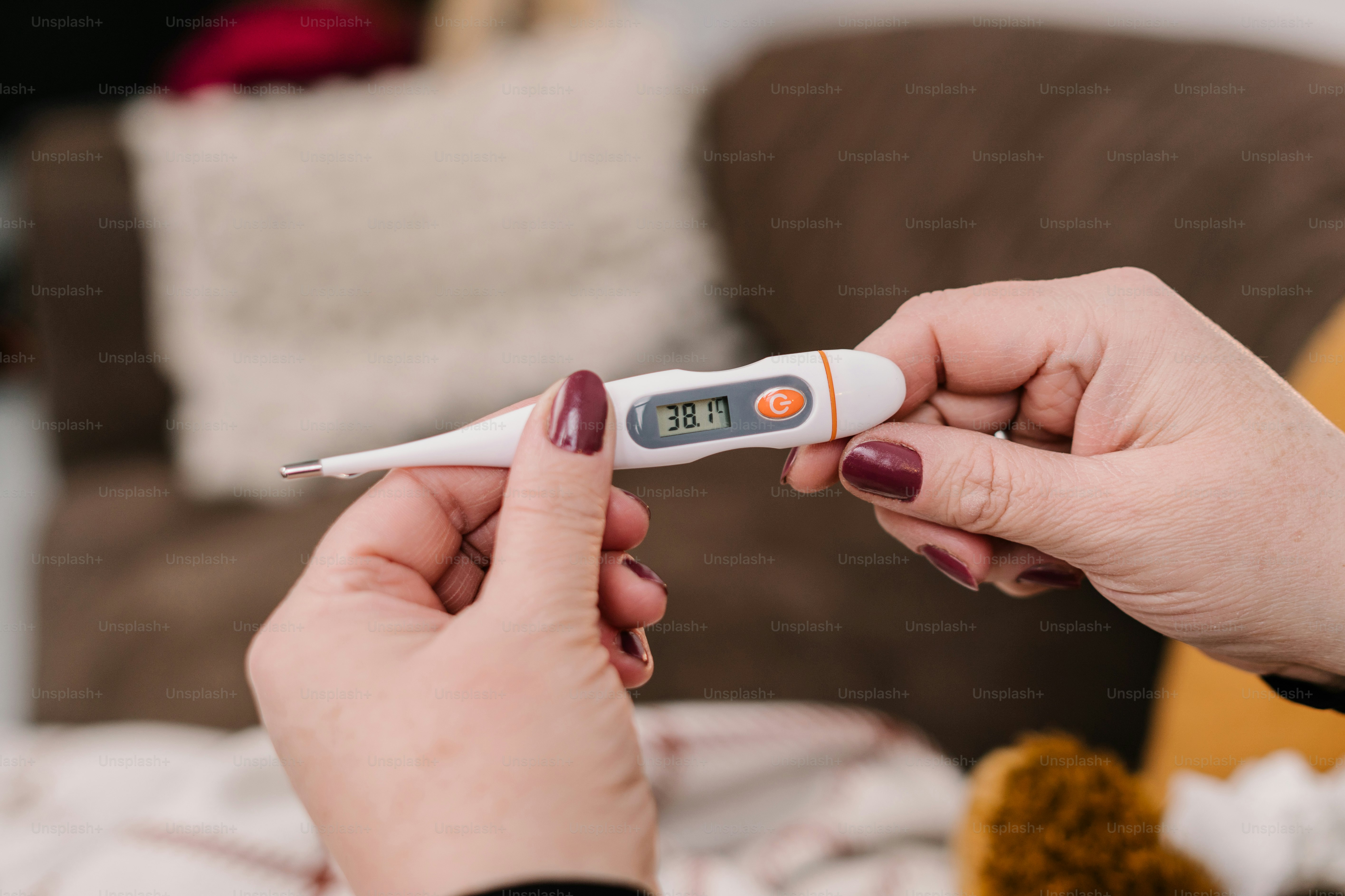 A woman holding a thermometer in her hand photo – Thermometer Image on ...