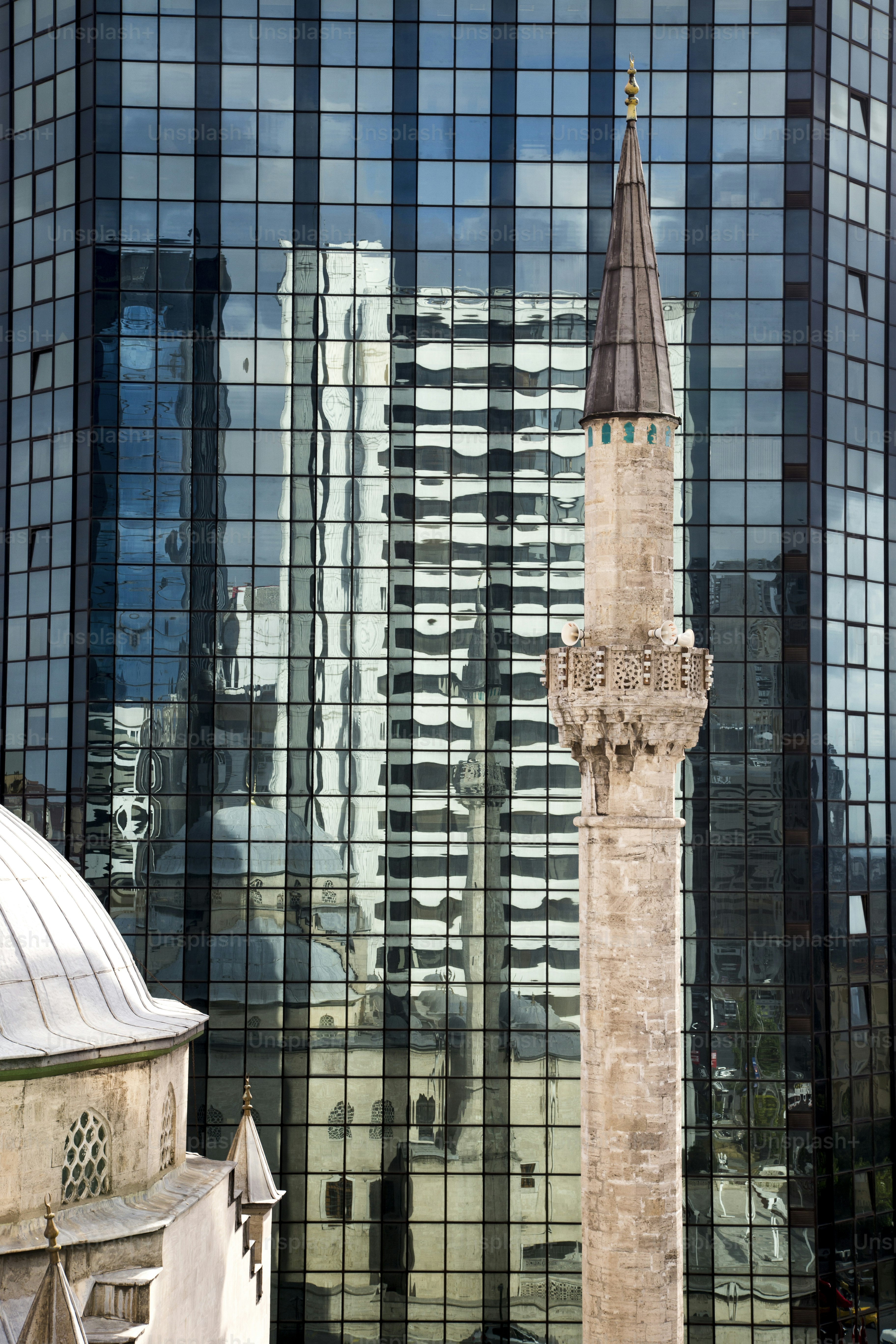 A clock tower in front of a glass building photo – Roof Image on Unsplash