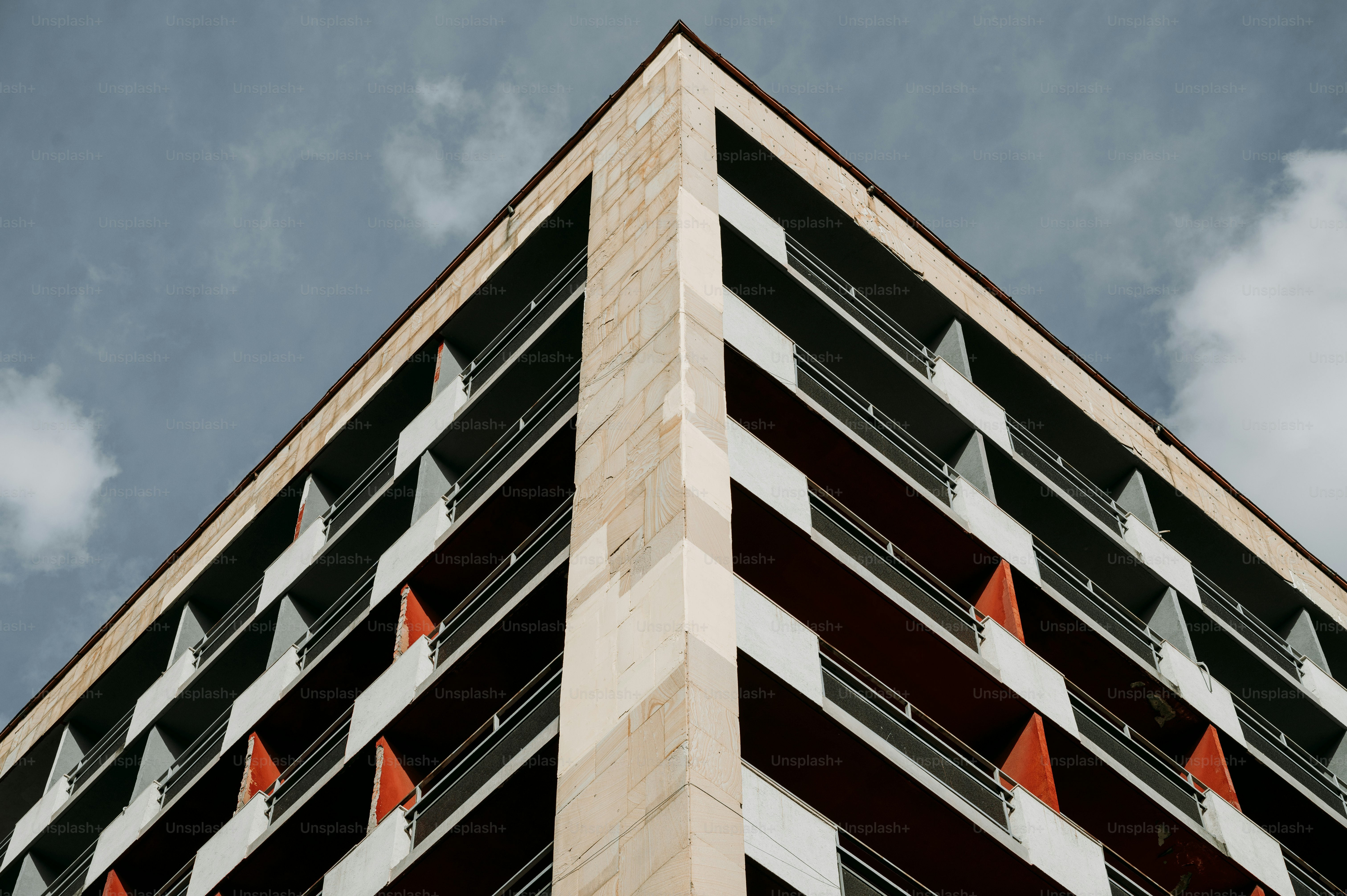 A tall building with red and white flags on it photo – Exterior Image ...
