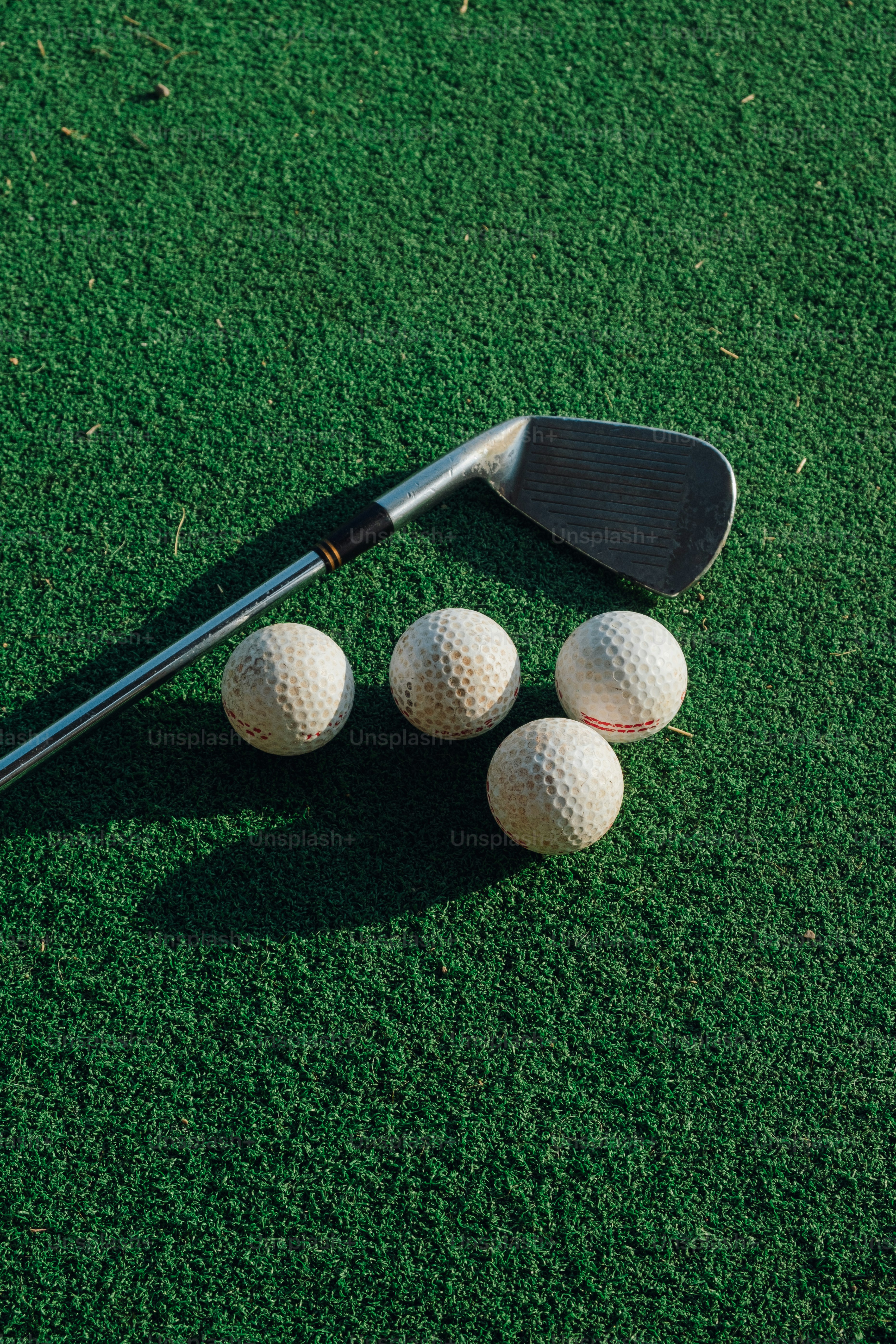 Three golf balls and a golf club on a putting green photo – Golfing ...