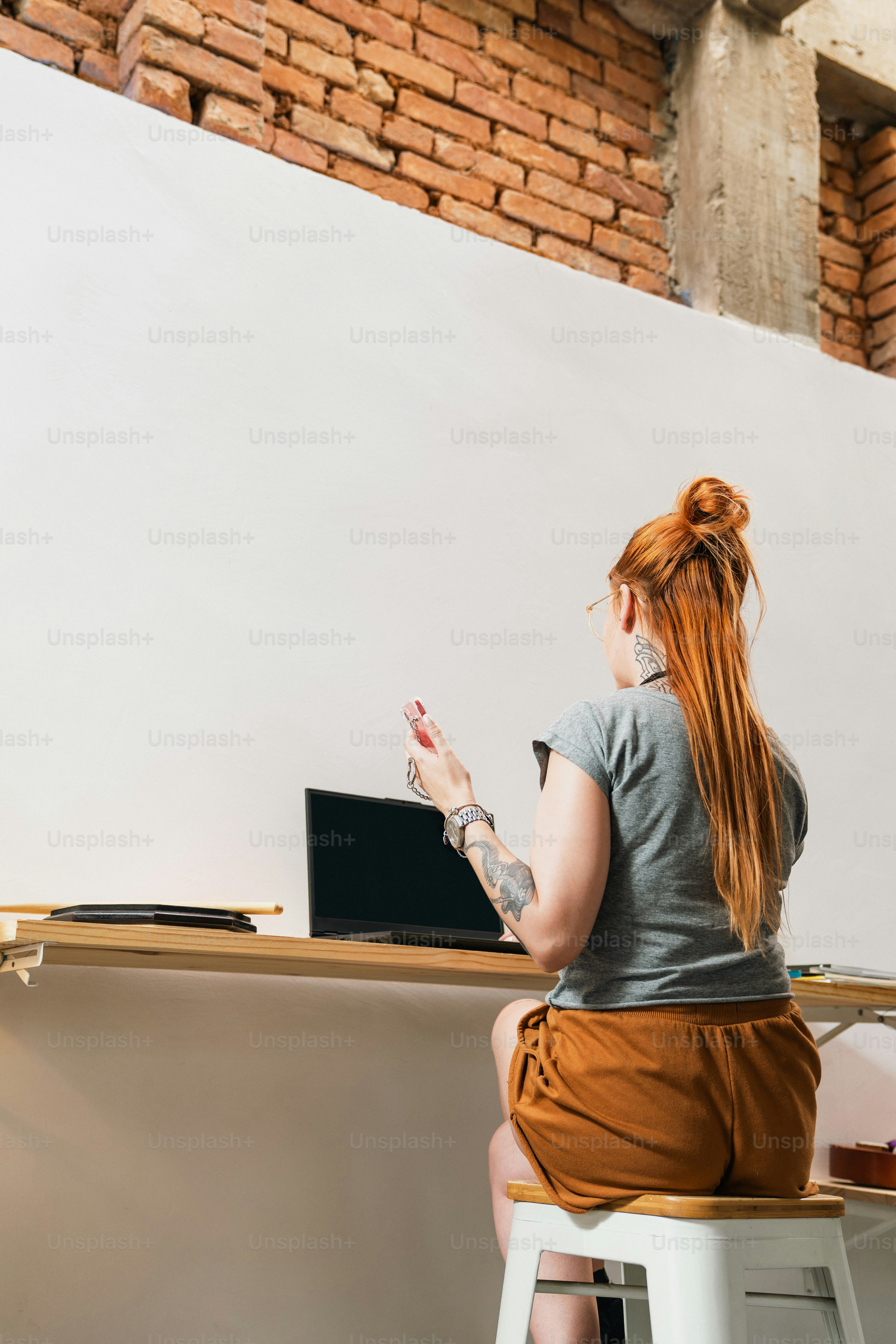 A woman sitting at a desk using a laptop computer photo – Business girl ...