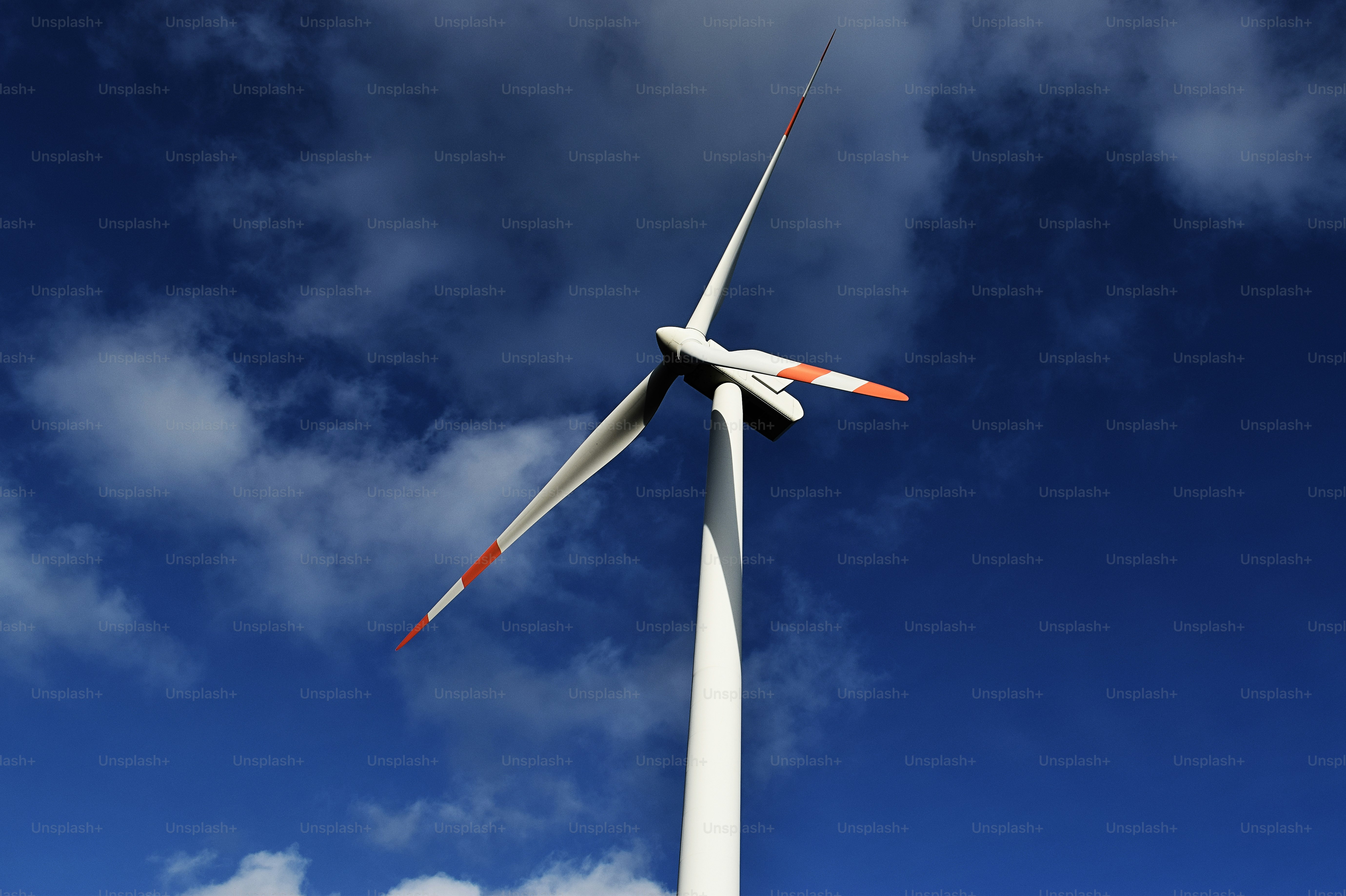 A wind turbine is shown against a blue sky photo – Wind turbine Image ...