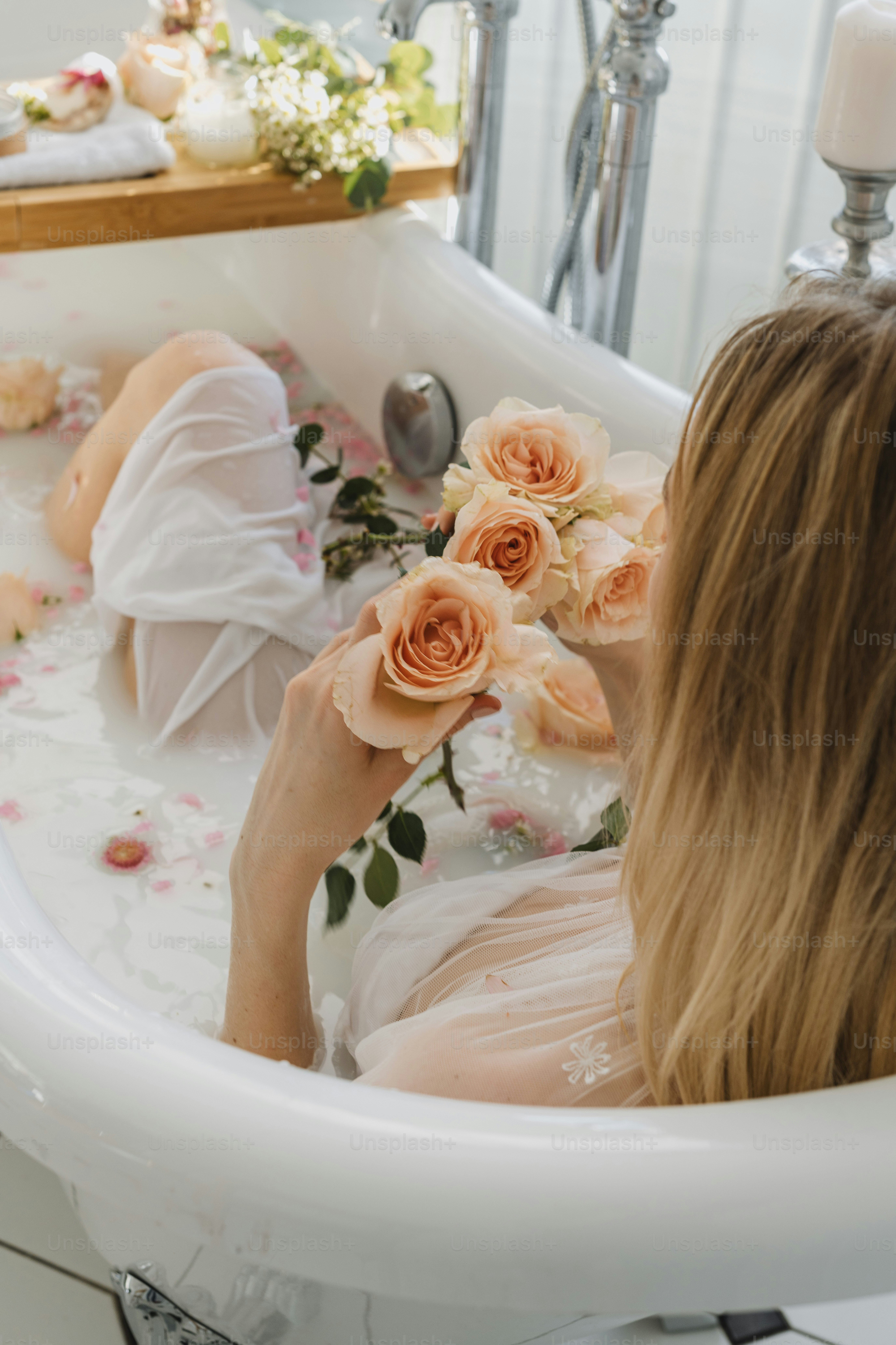 Una donna seduta in una vasca da bagno piena di fiori foto – Immagine ...