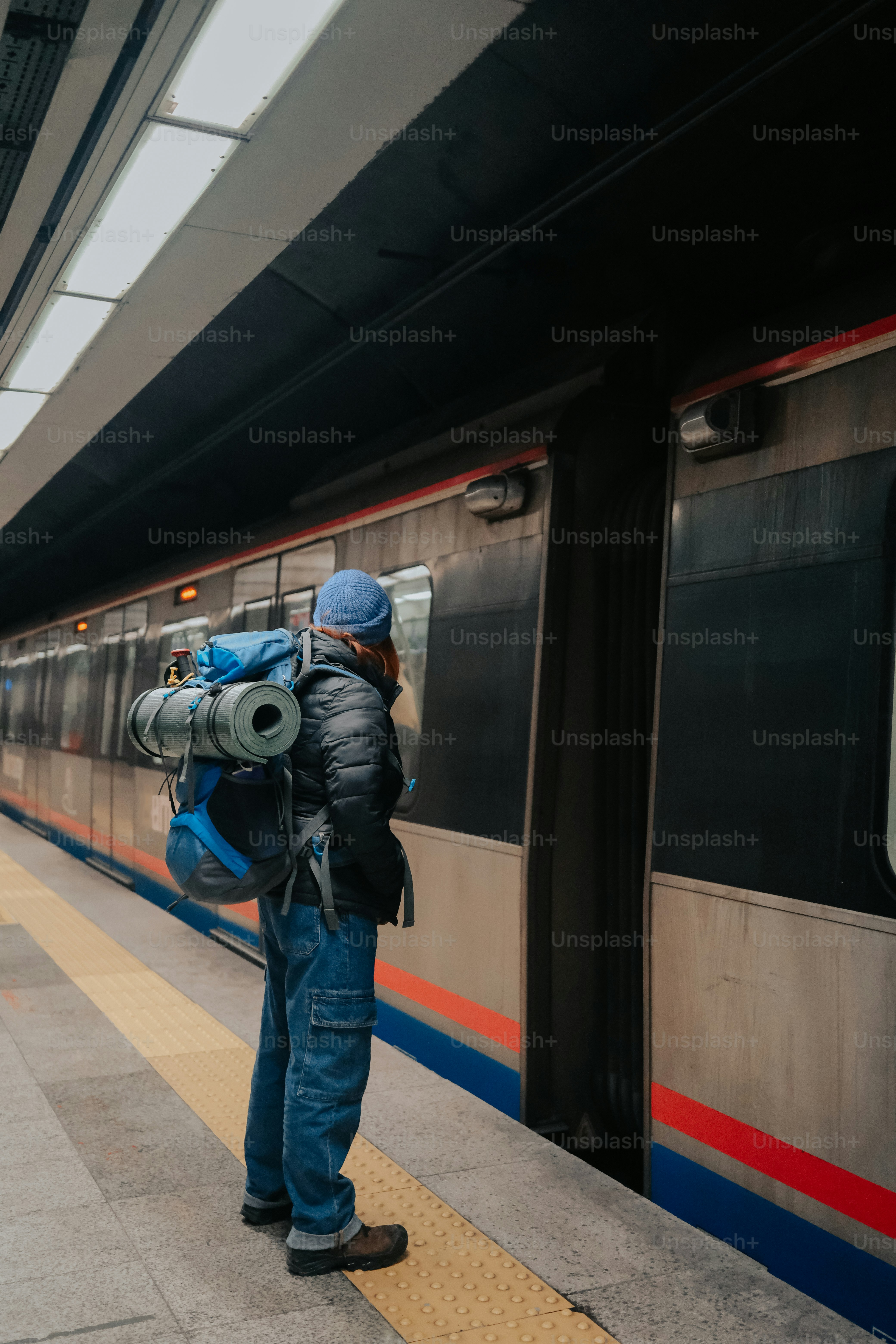 A person with a backpack standing in front of a train photo – Backpacks ...