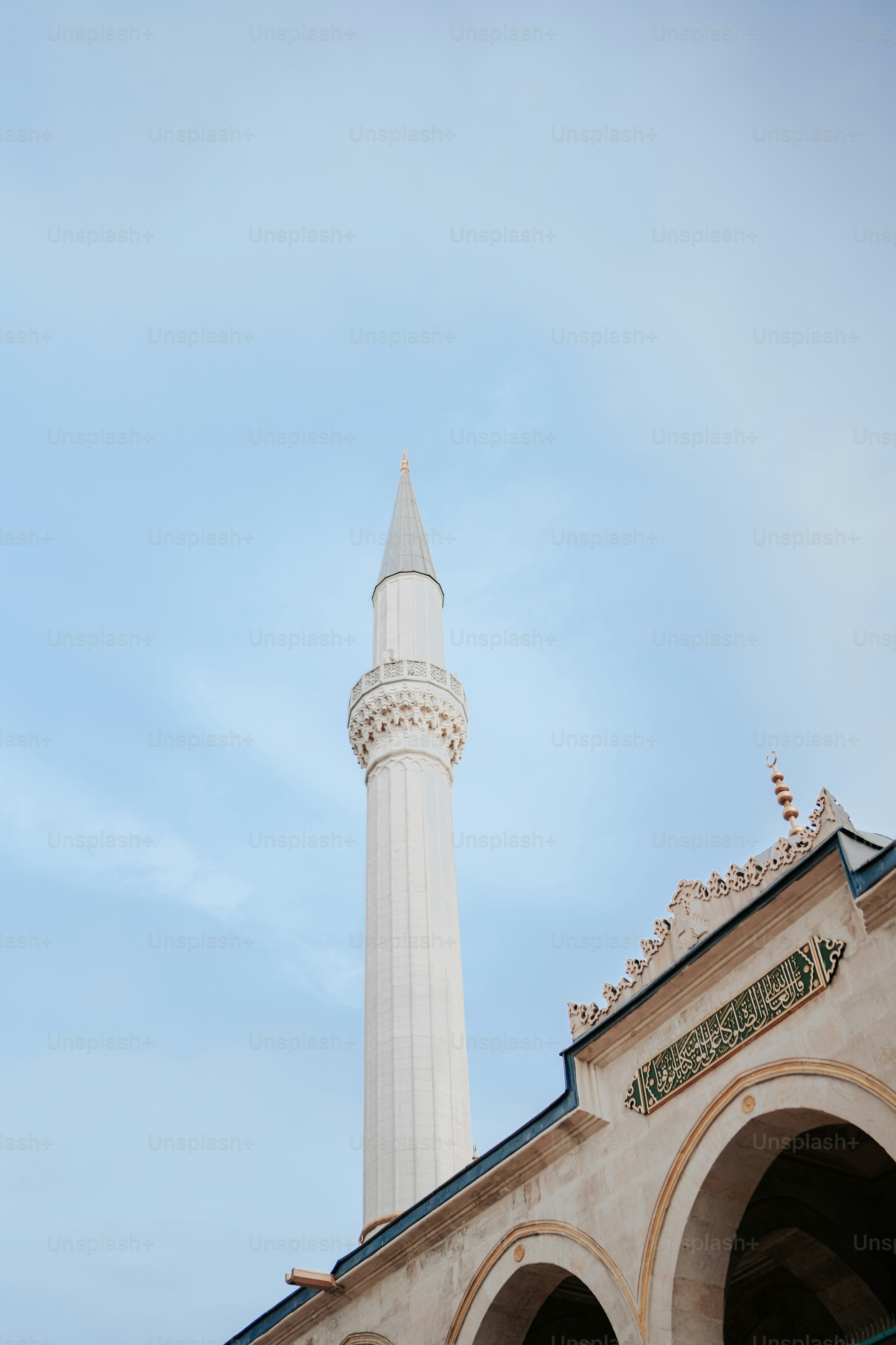 A tall white tower with a clock on it's side photo – Mosque ...