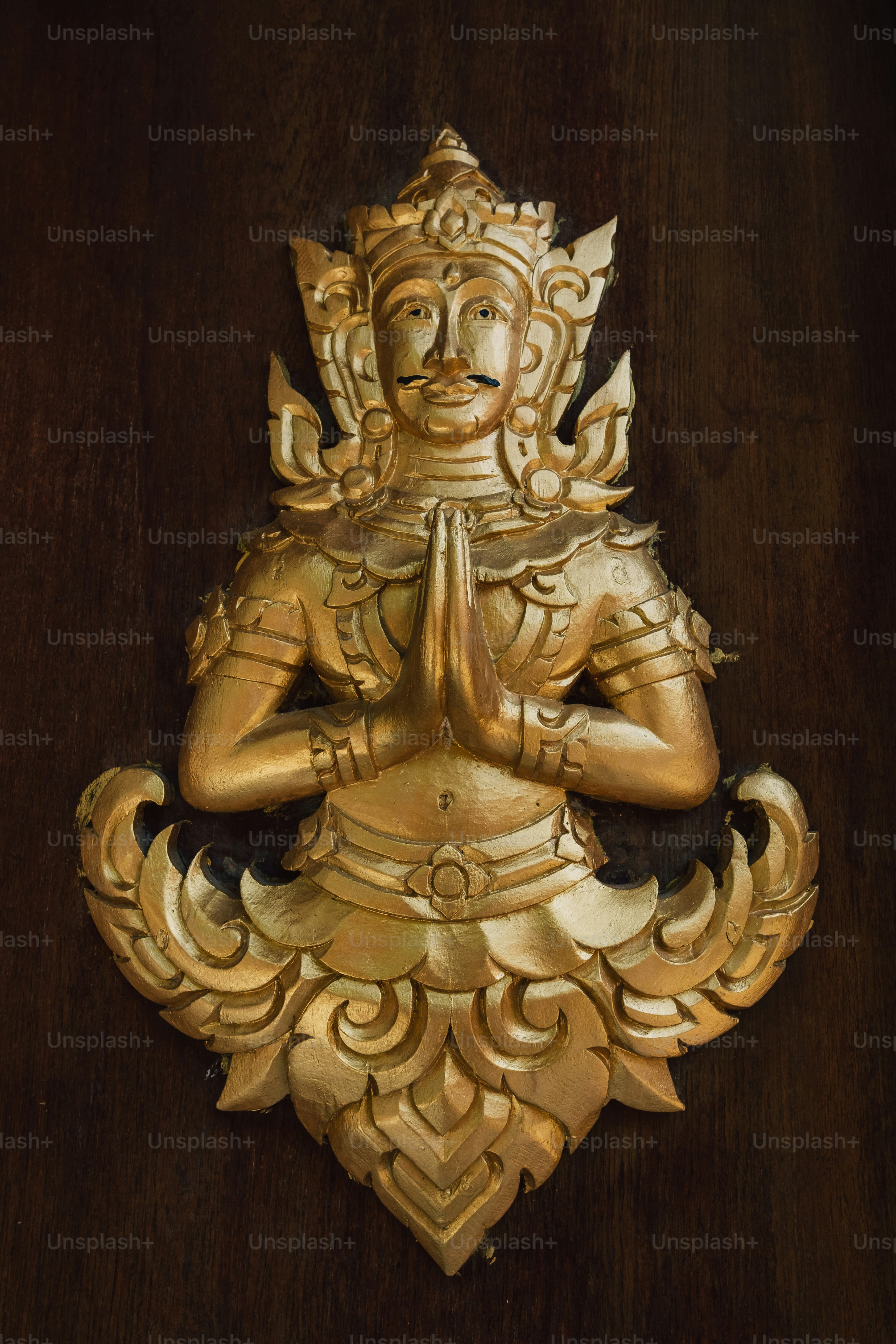 A golden statue of a person sitting in a lotus position photo ...