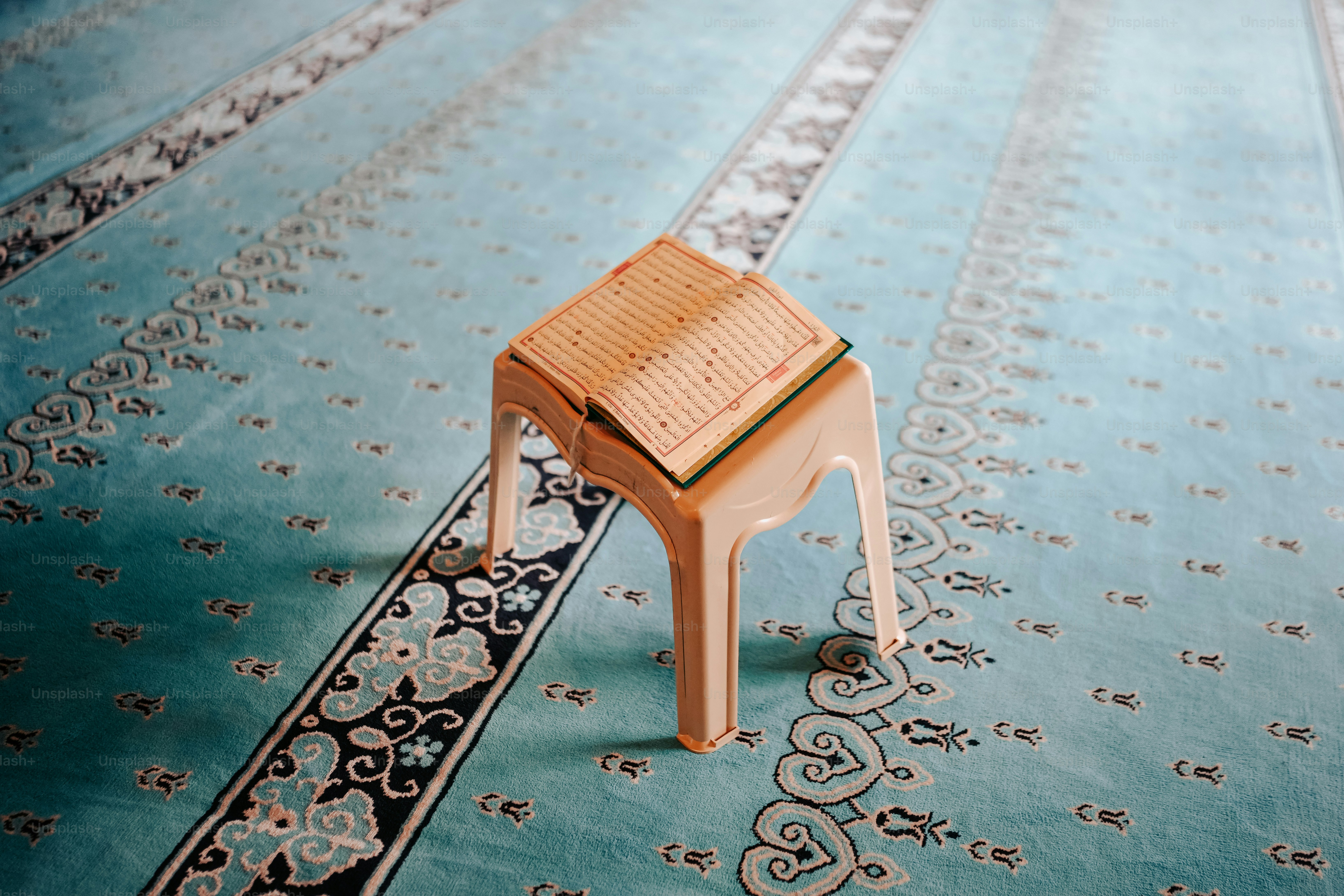 A small wooden stool sitting on top of a rug photo – Muslim Image on ...