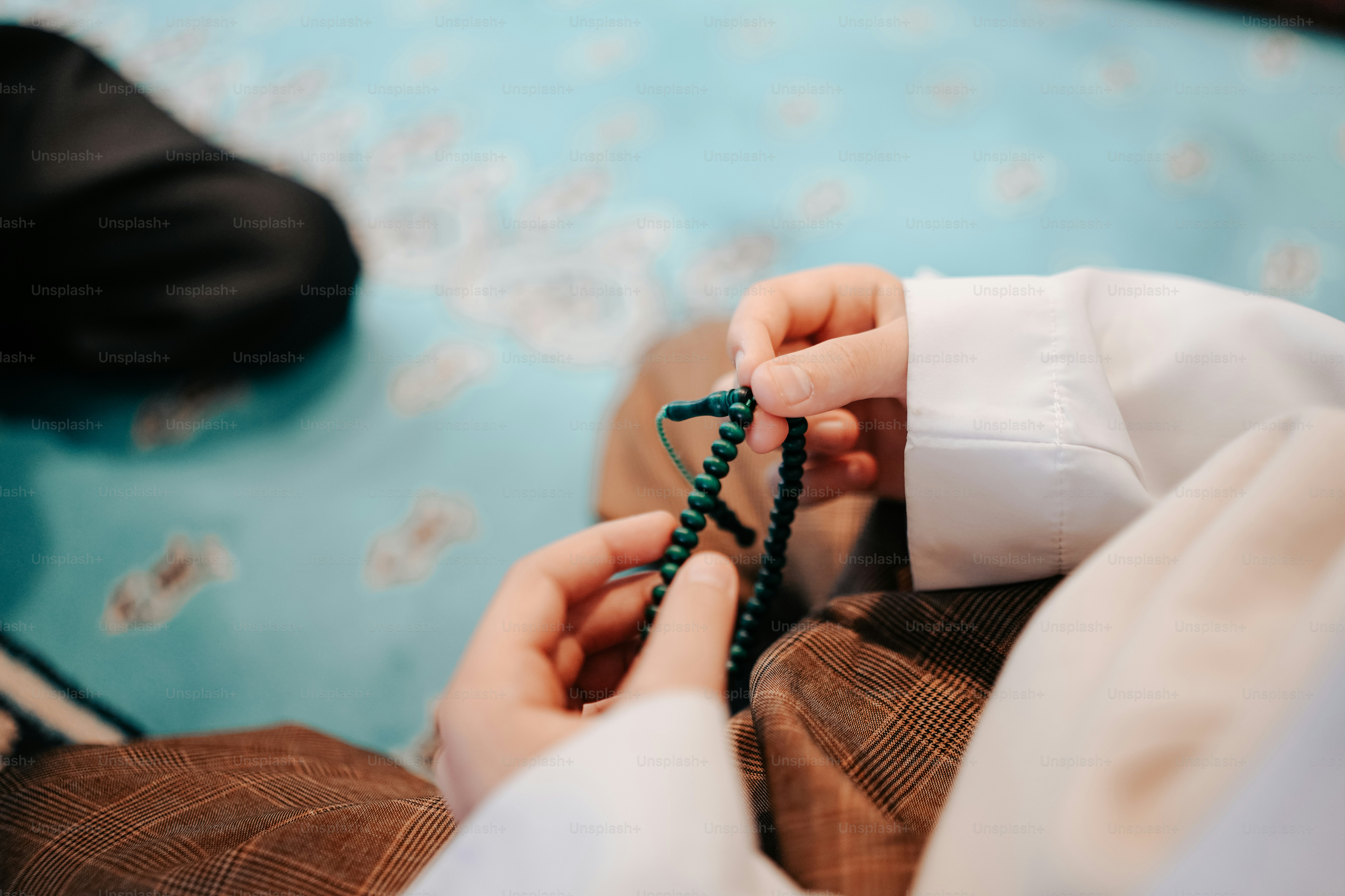 A person holding a string of string in their hands photo – Holy Image ...