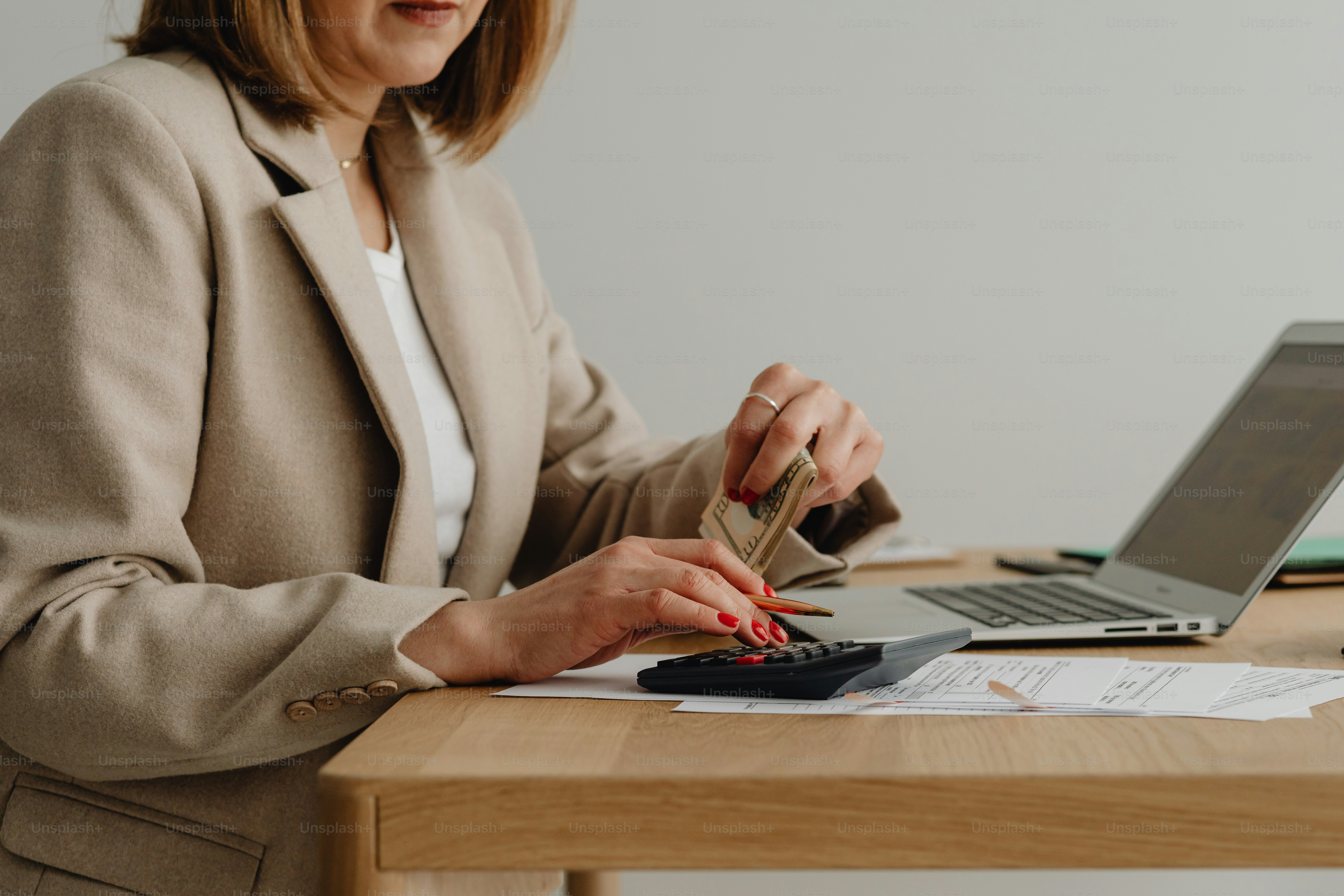 A calculator sitting on top of a desk next to a laptop photo – Tax ...