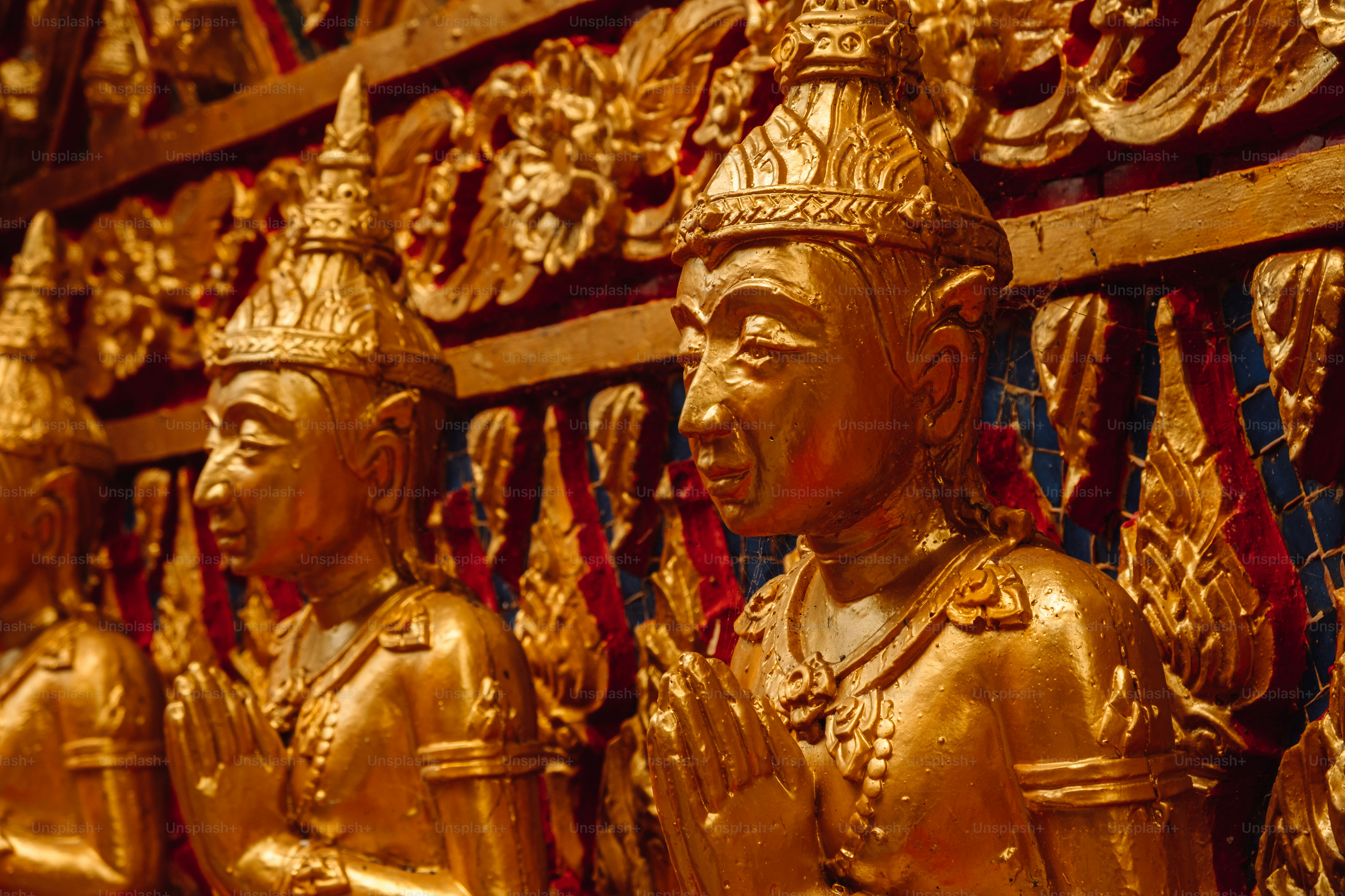 A row of golden statues sitting next to each other photo – Temple Image ...